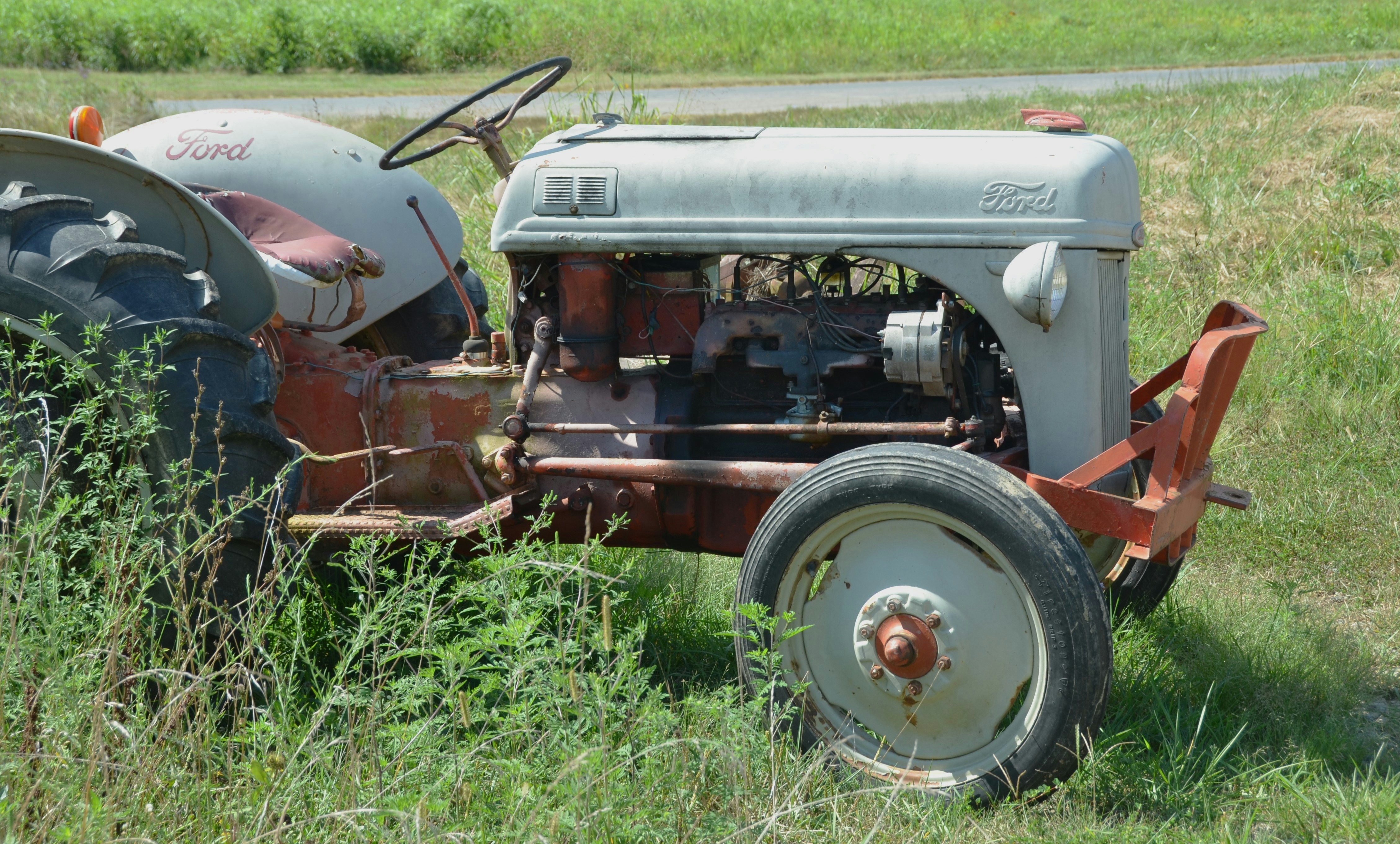 Old ford tractor sitting in tall grass