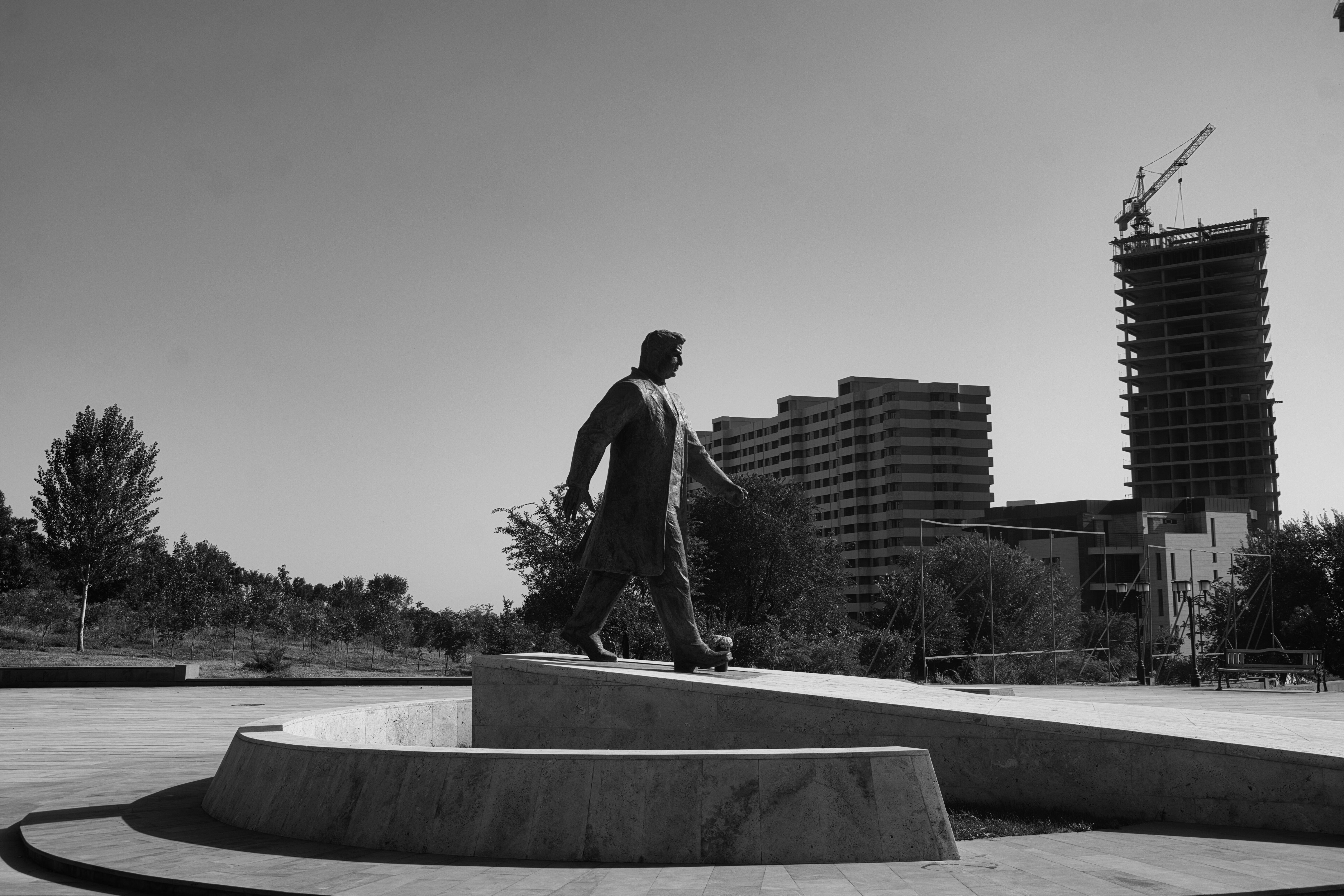 Stride on the Concrete Arc: A Lone Figure Amid Rising Steel