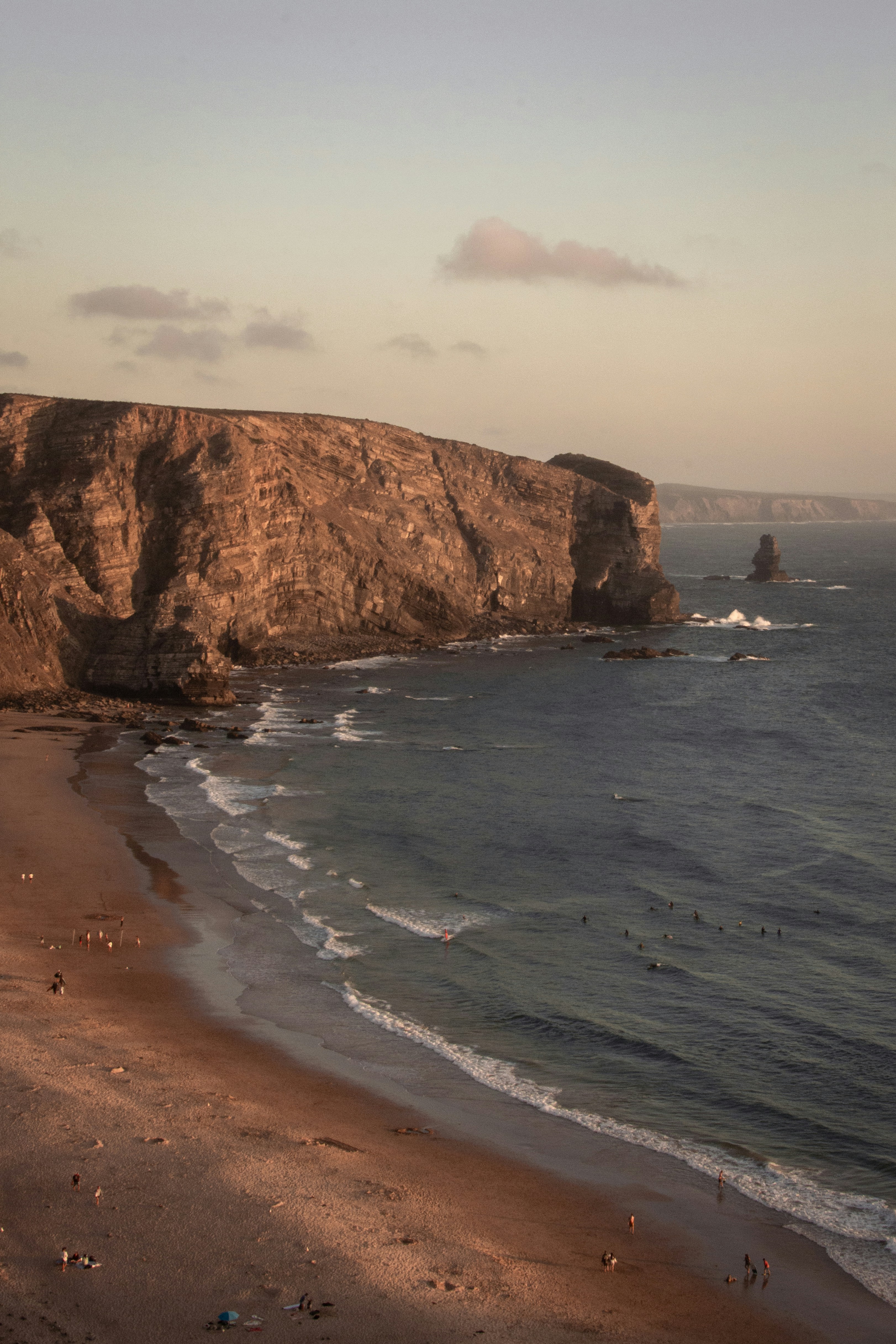Coastal cliffs and ocean waves at sunset