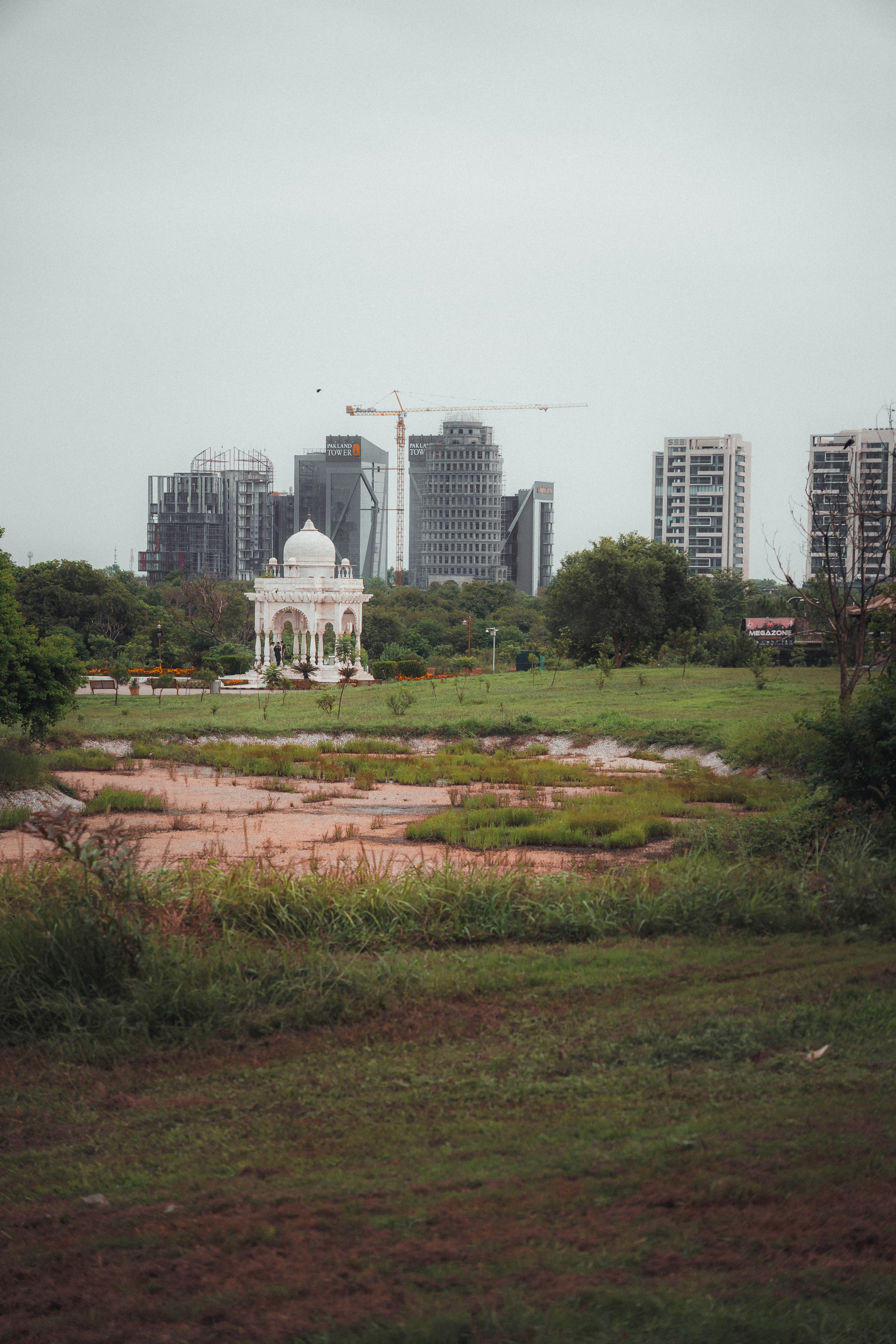 White pavilion in park with city skyline background