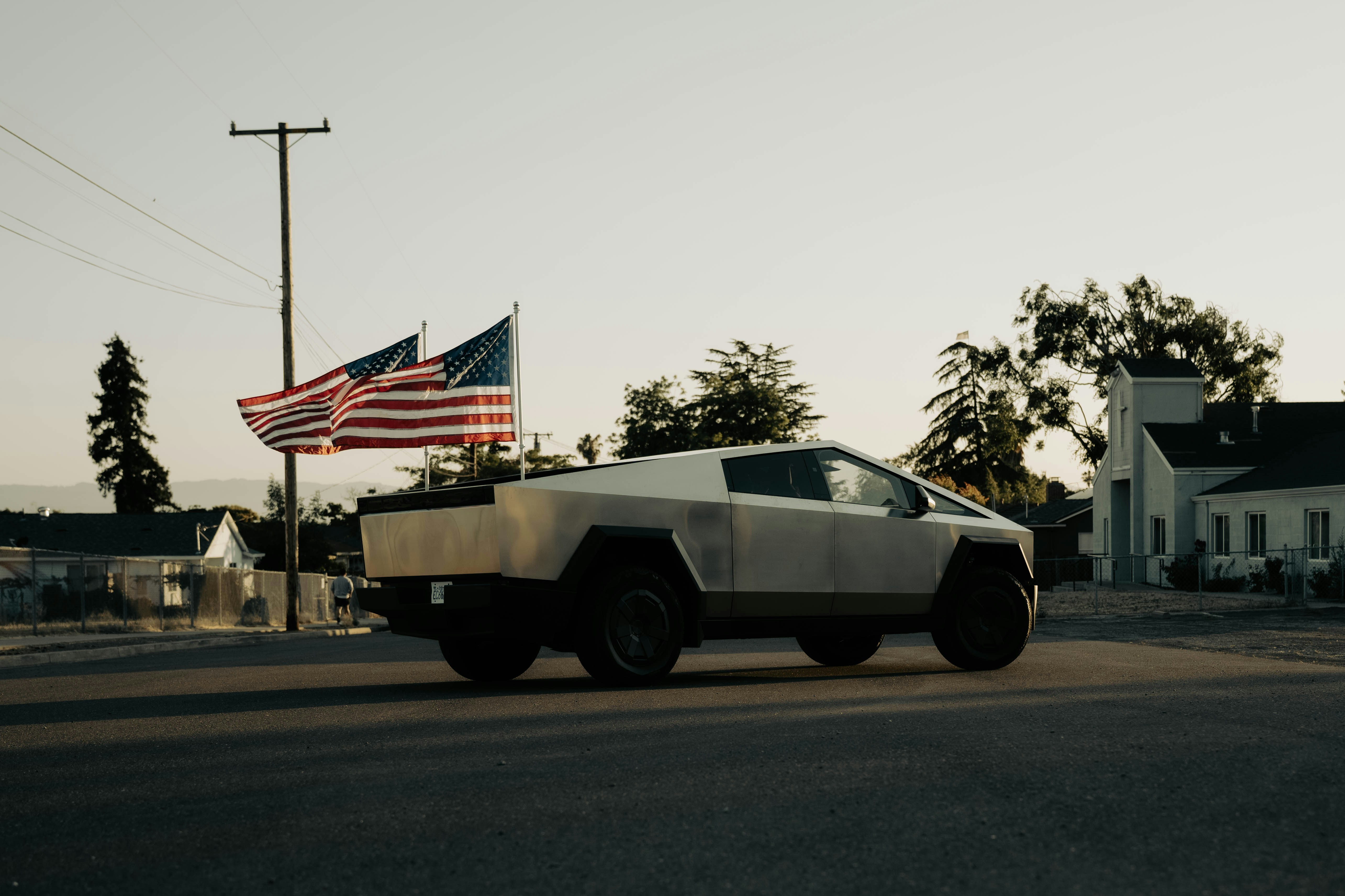 Futuristic truck drives past american flags