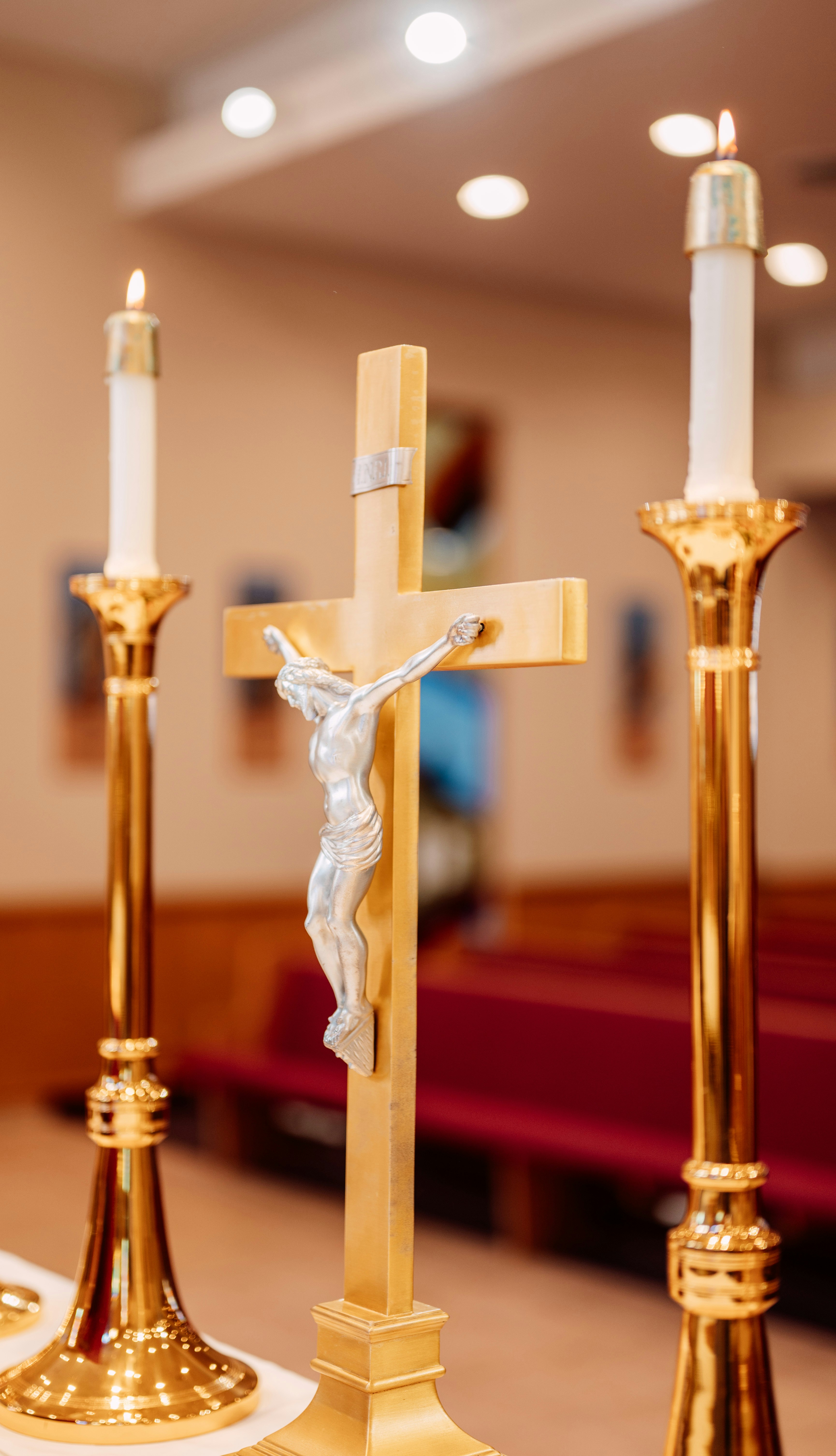 A crucifix with two lit candles in a church.