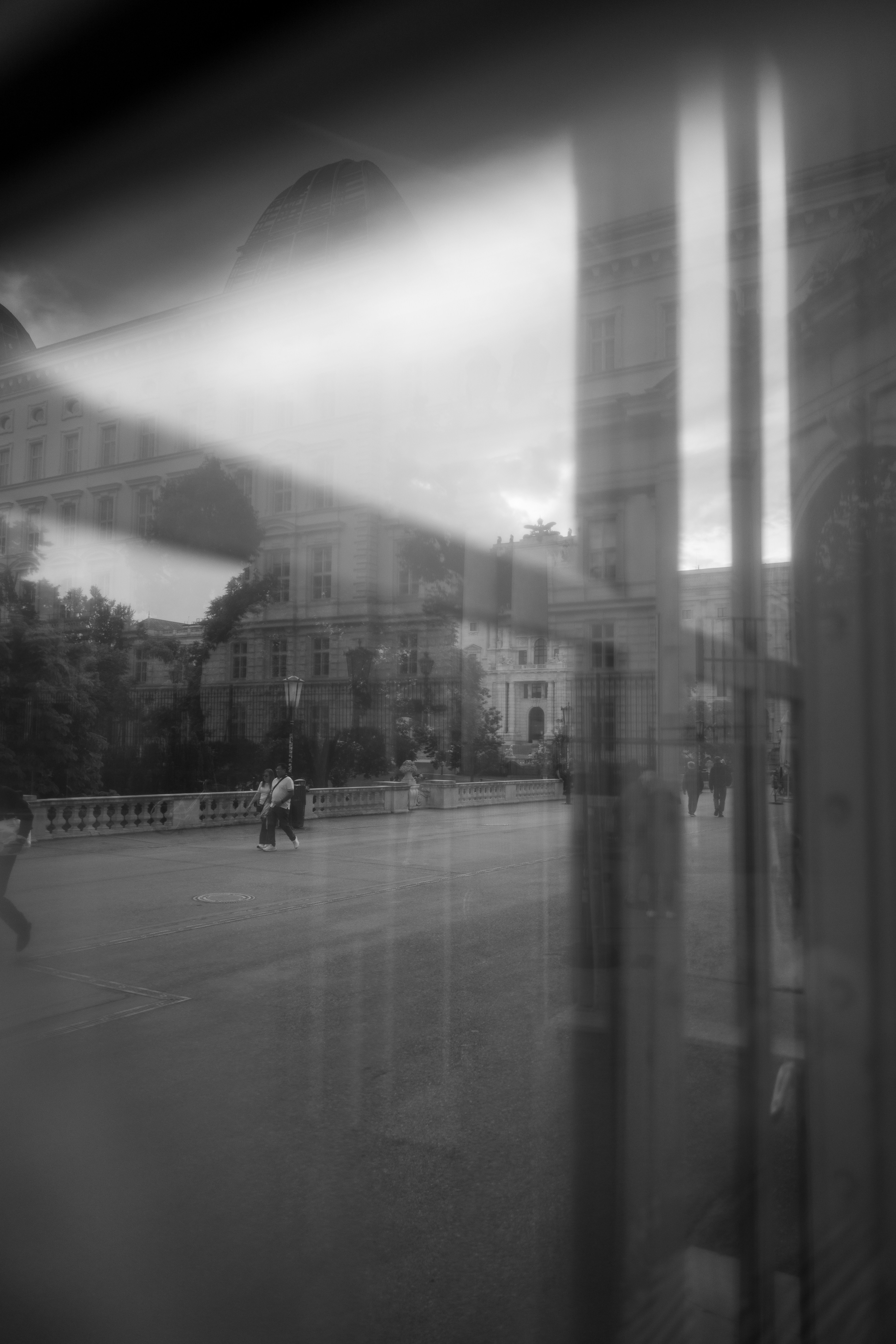 Reflections of buildings and people on a wet street