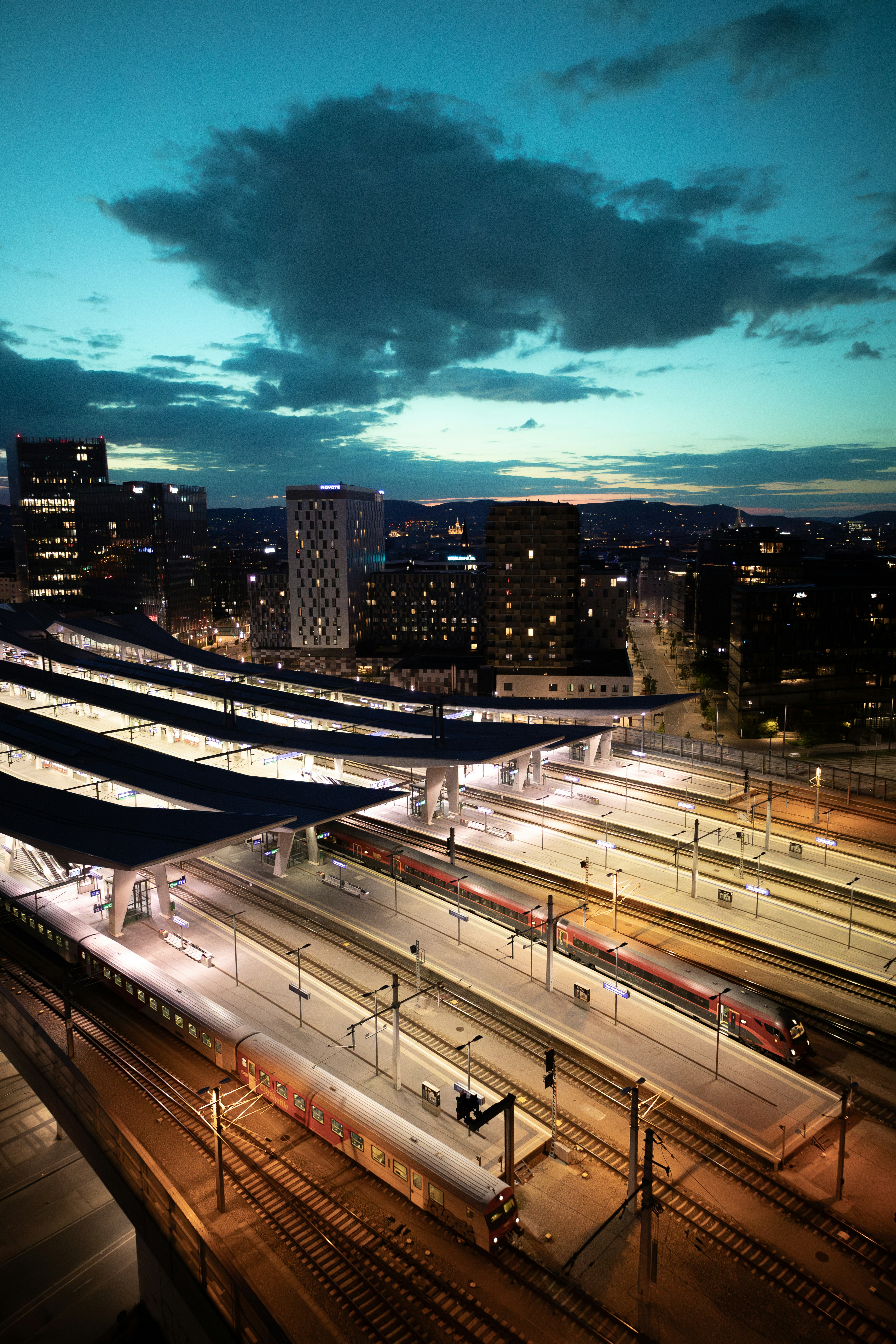 Modern train station with illuminated tracks at dusk