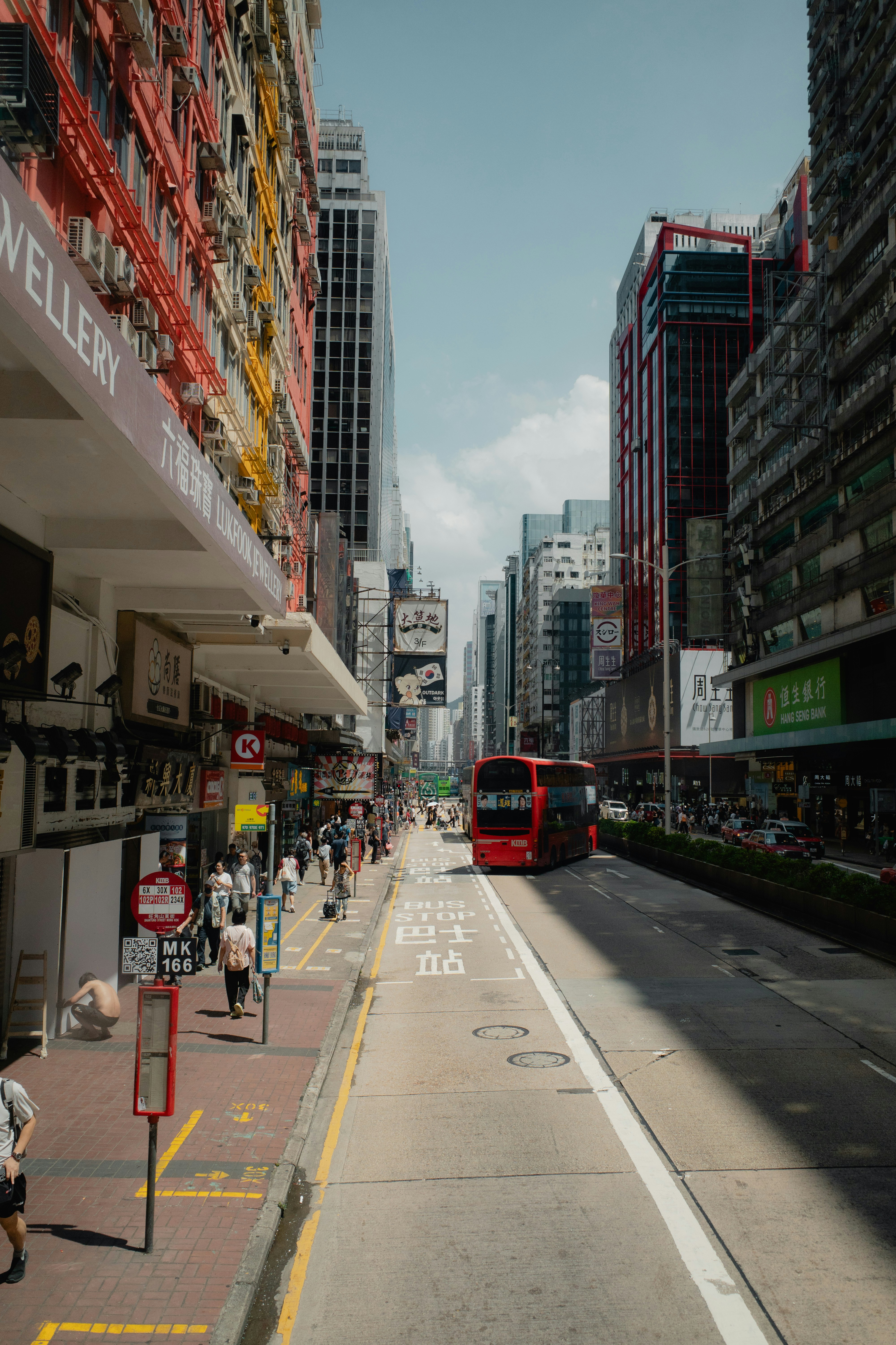 Red double-decker bus on a busy city street.