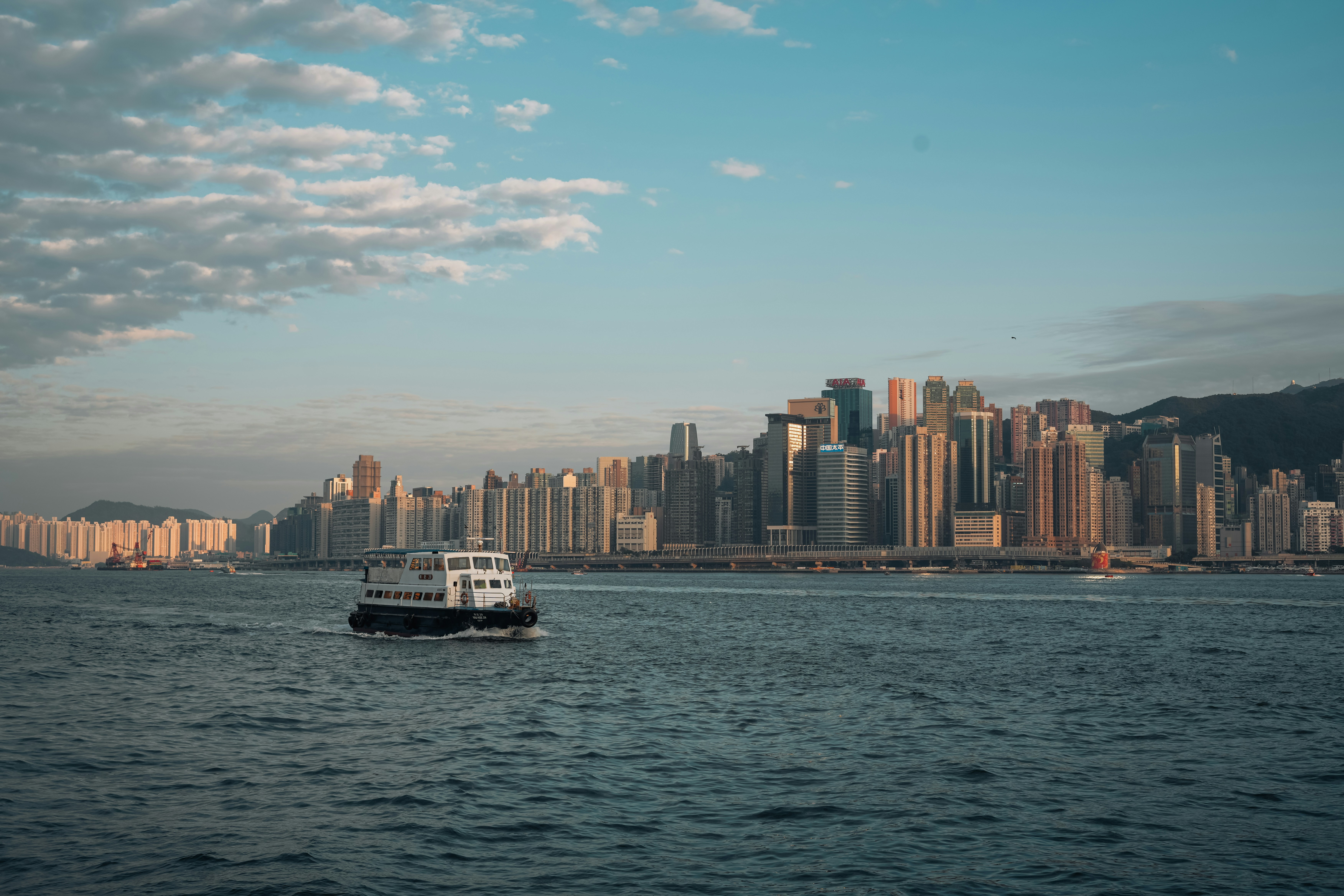 Hong Kong Street View - Sun Hung | Ferry boat on water with city skyline background