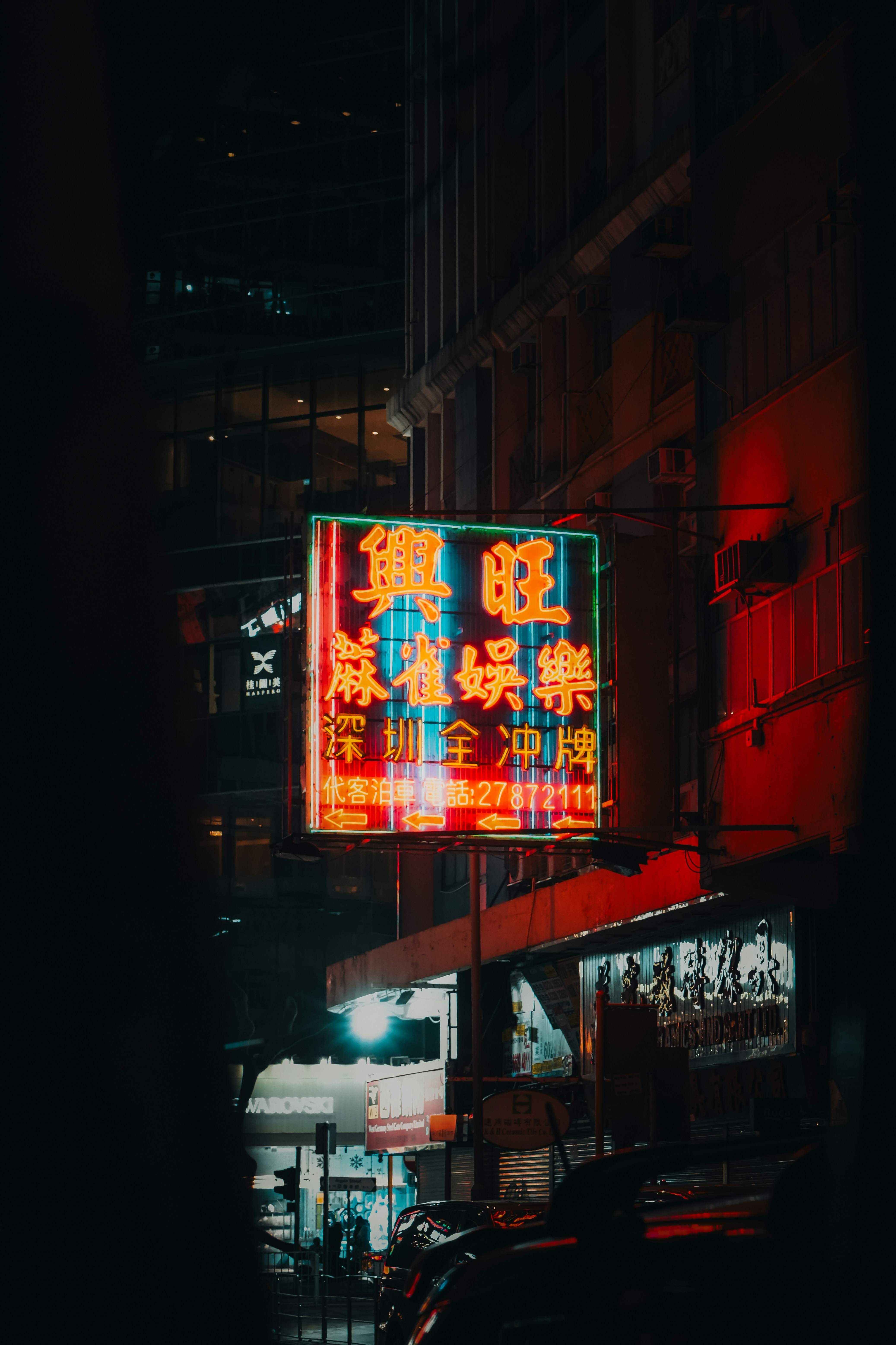 Hong Kong Street View - Sun Hung | Neon signs illuminate a dark city street at night.