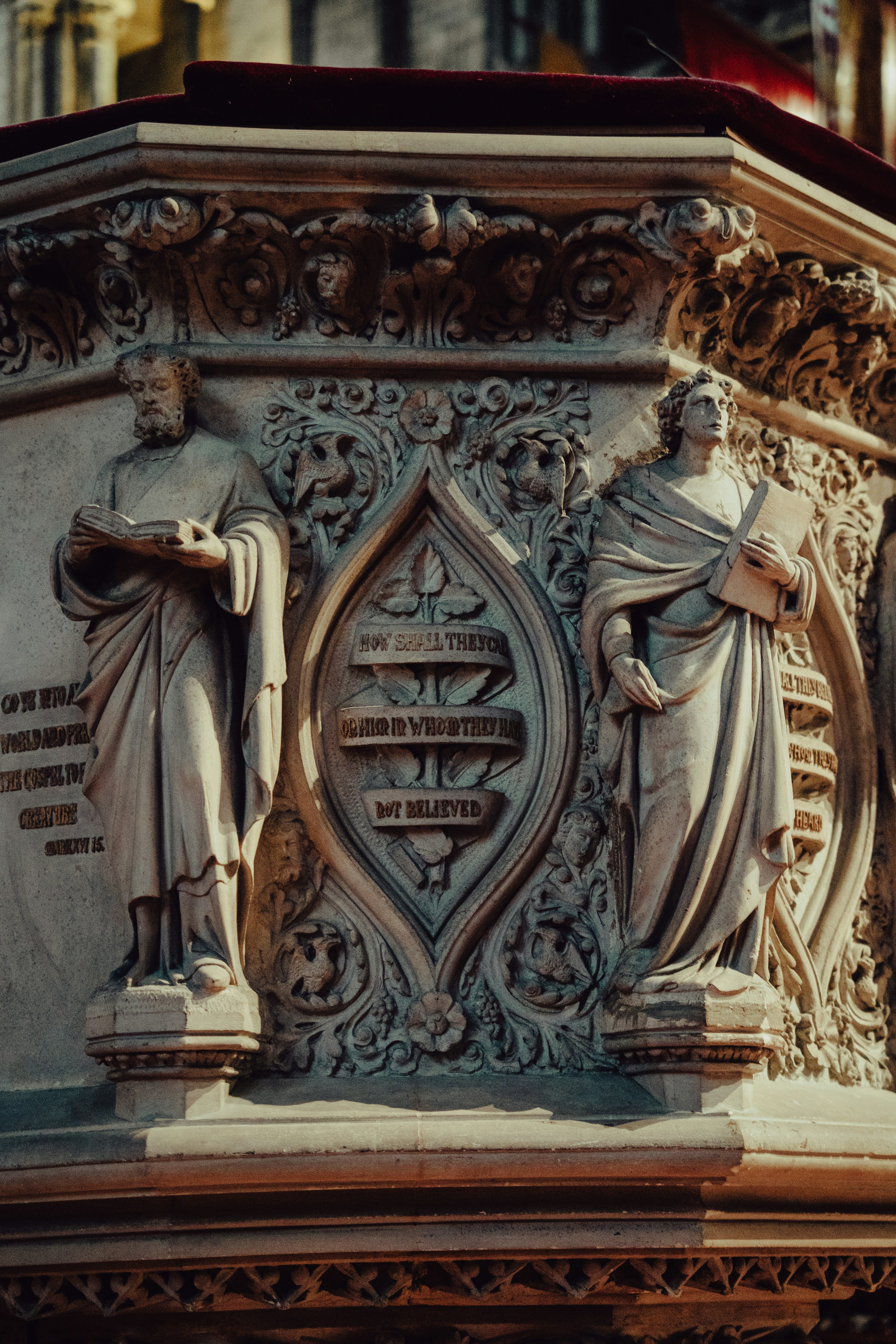 Ornate stone carving with religious figures and text.