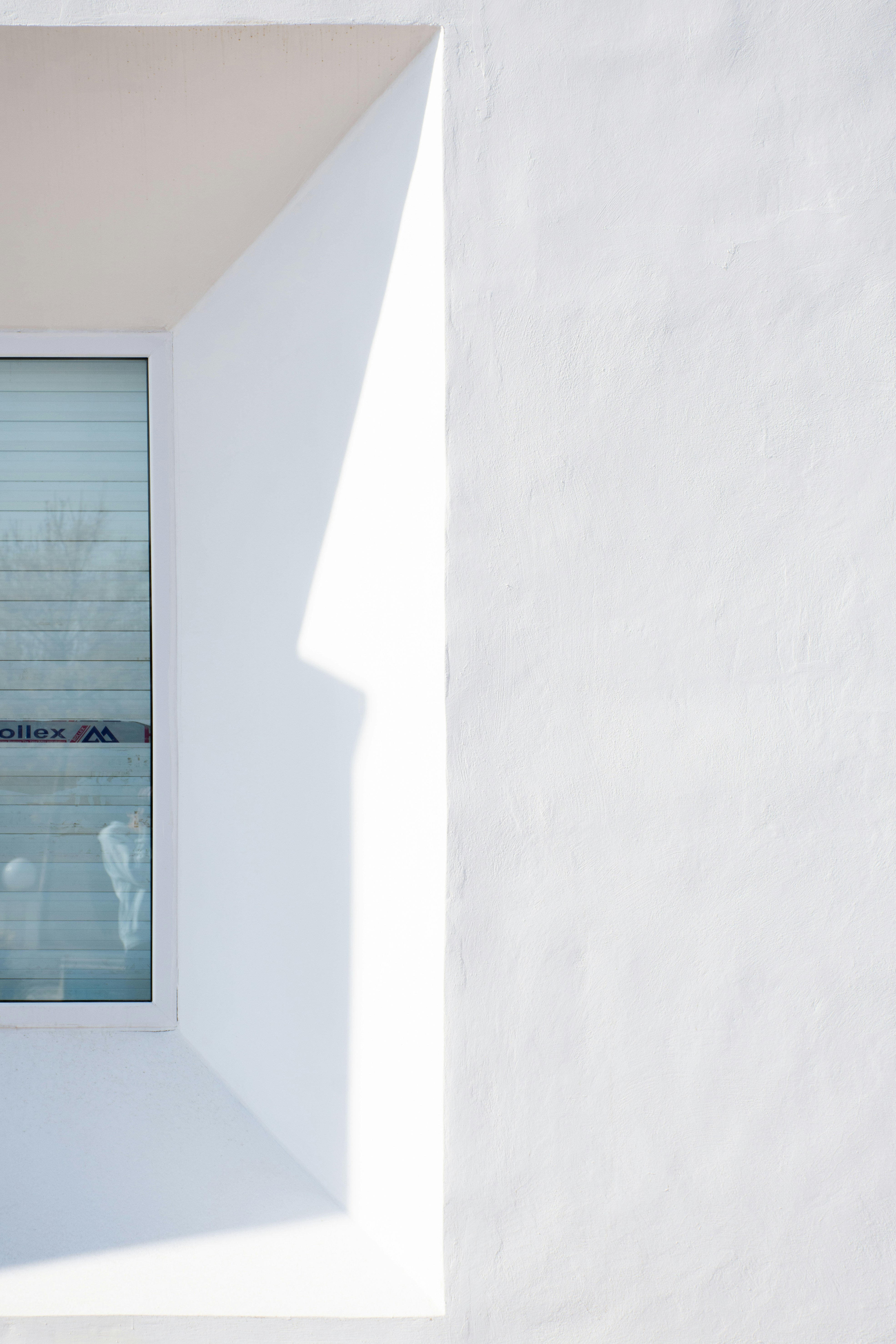 White wall with geometric shadows and window