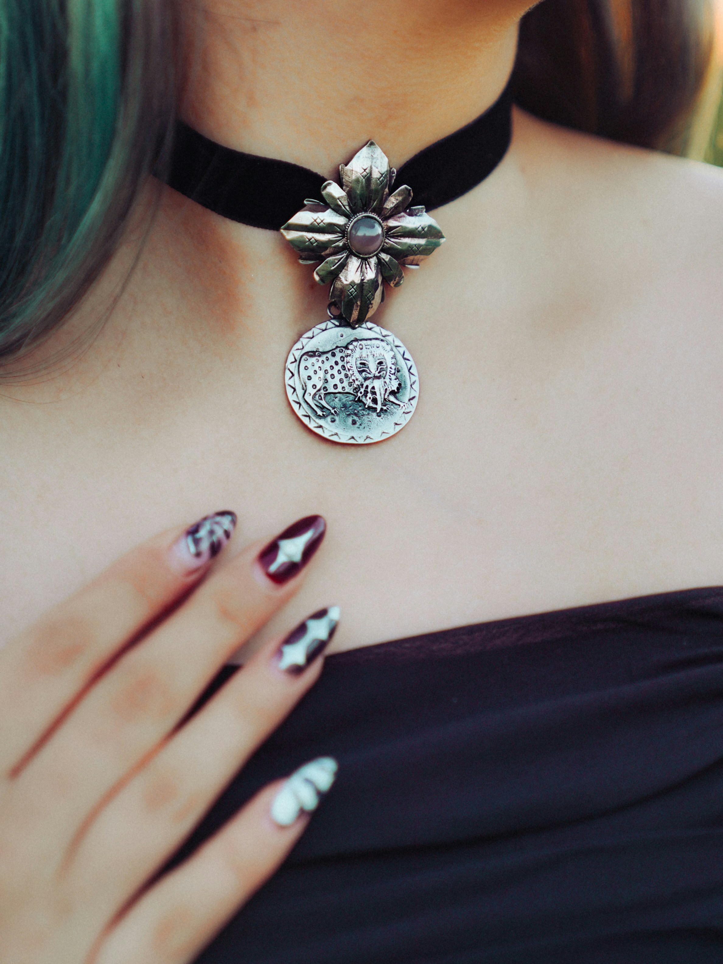 Woman wearing a velvet choker with a medallion pendant