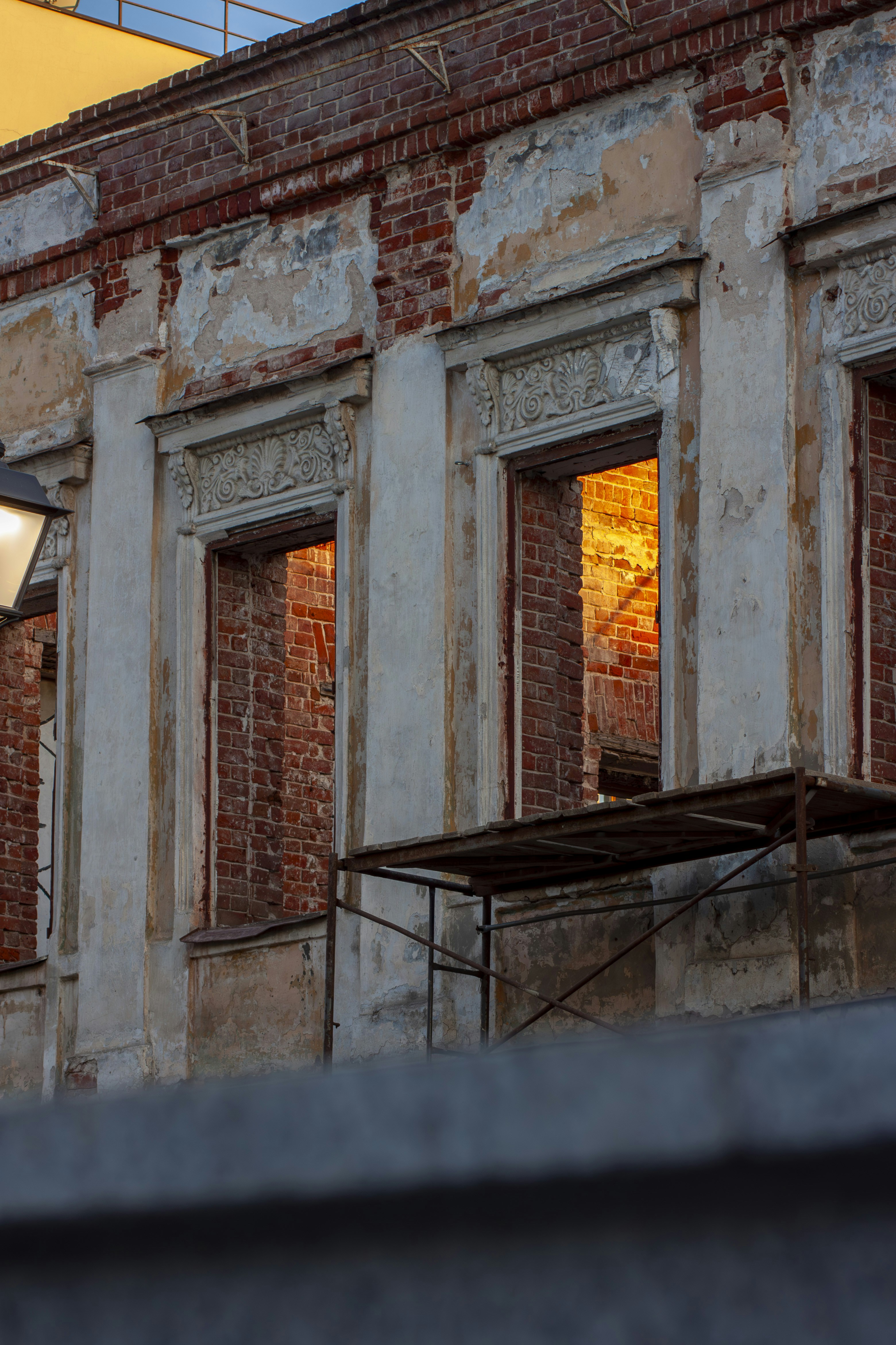 Old brick building with glowing windows at sunset