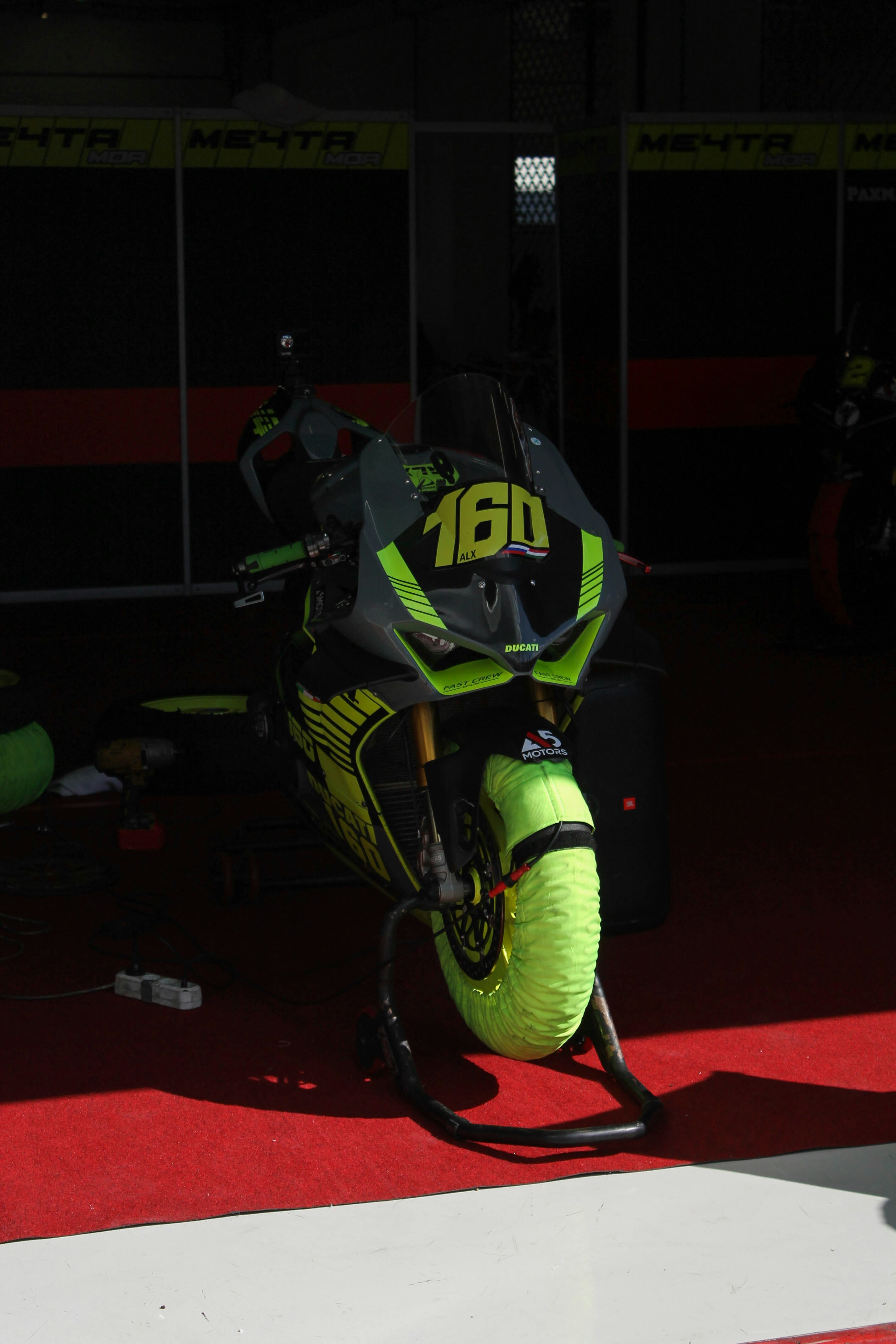 A racing motorcycle with number 160 in a pit stop.