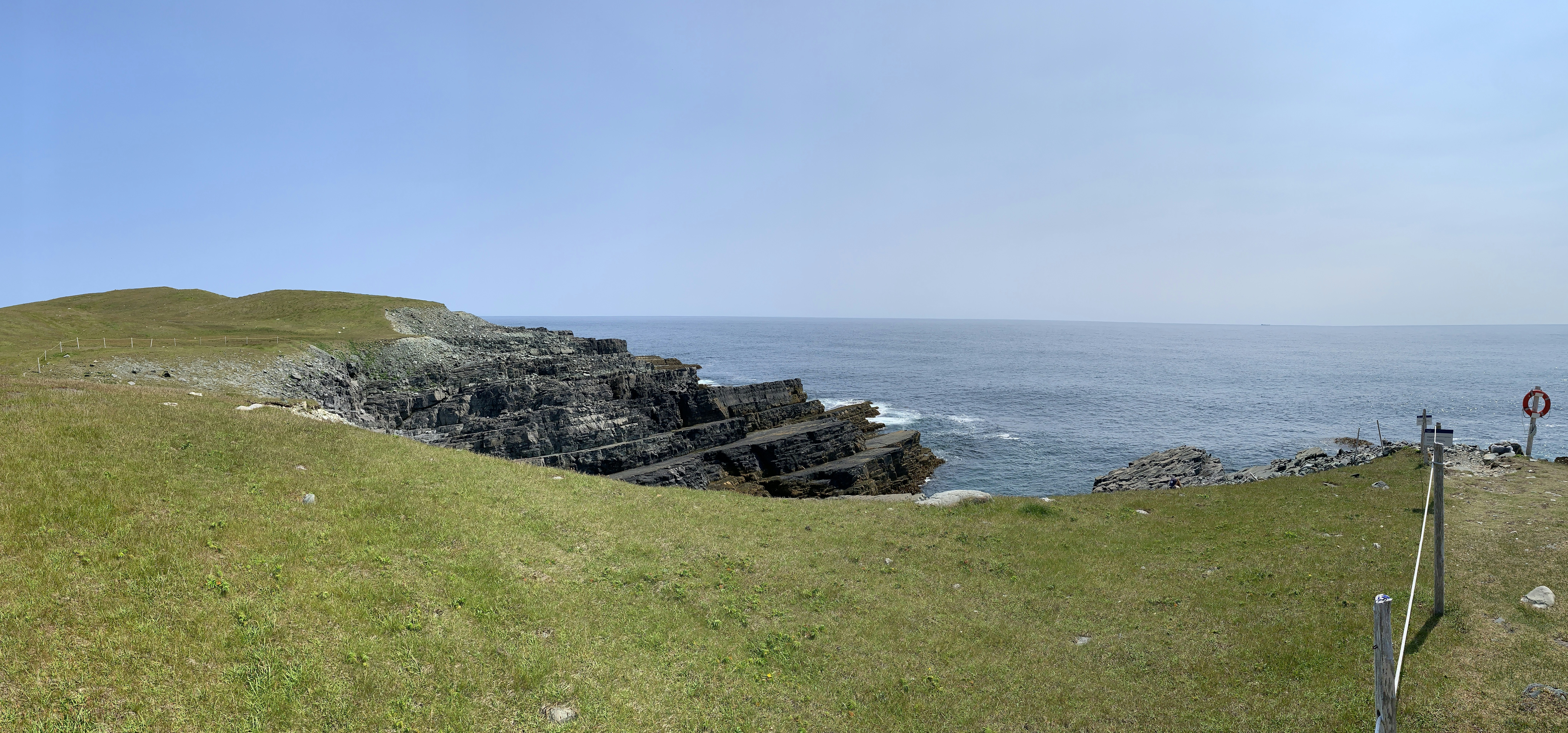 Grassy coastline with rocky cliffs and the ocean