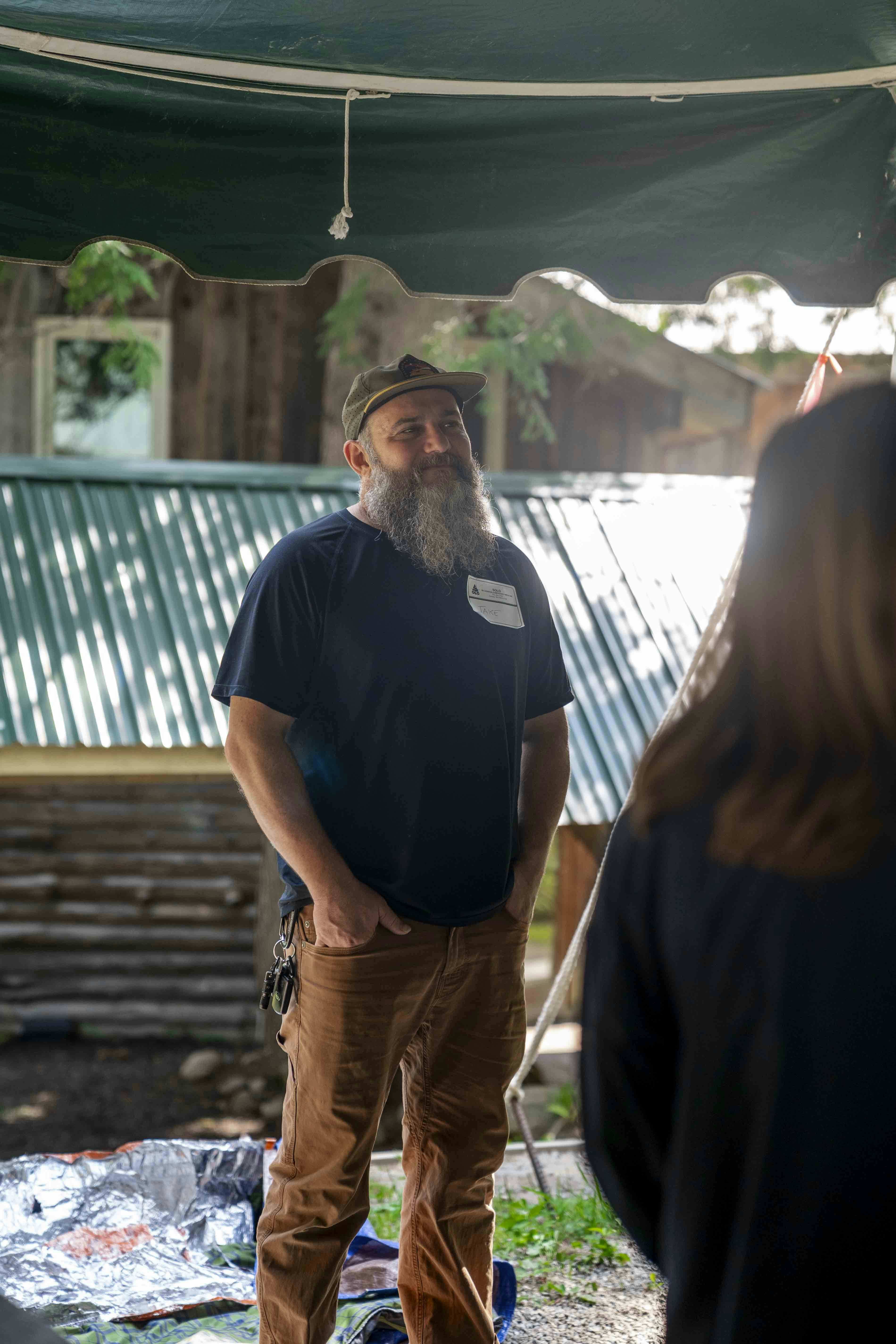 Bearded Host Beneath the Canopy: Quiet Presence at an Outdoor Gathering