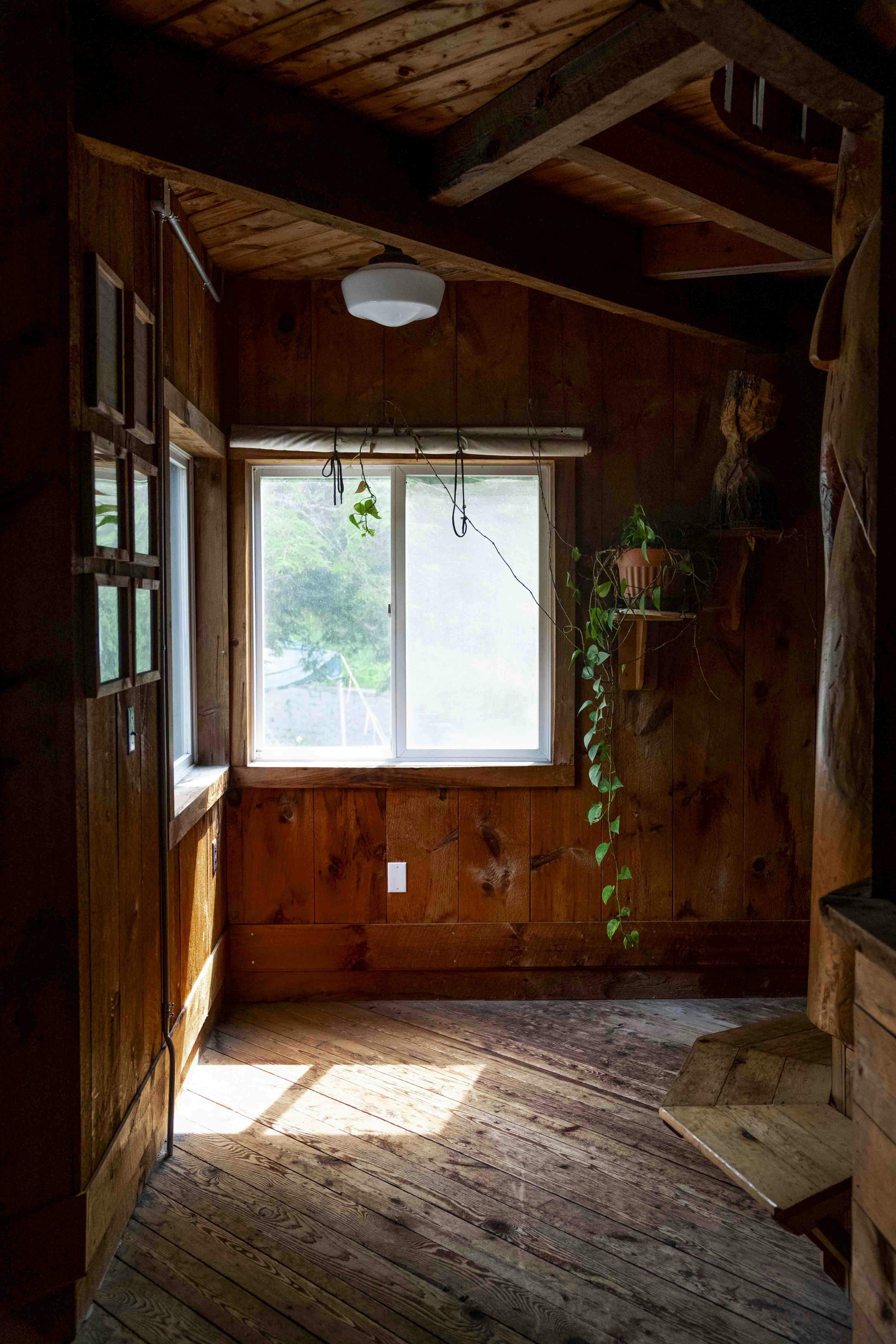 Rustic wooden room with large window and sunlight