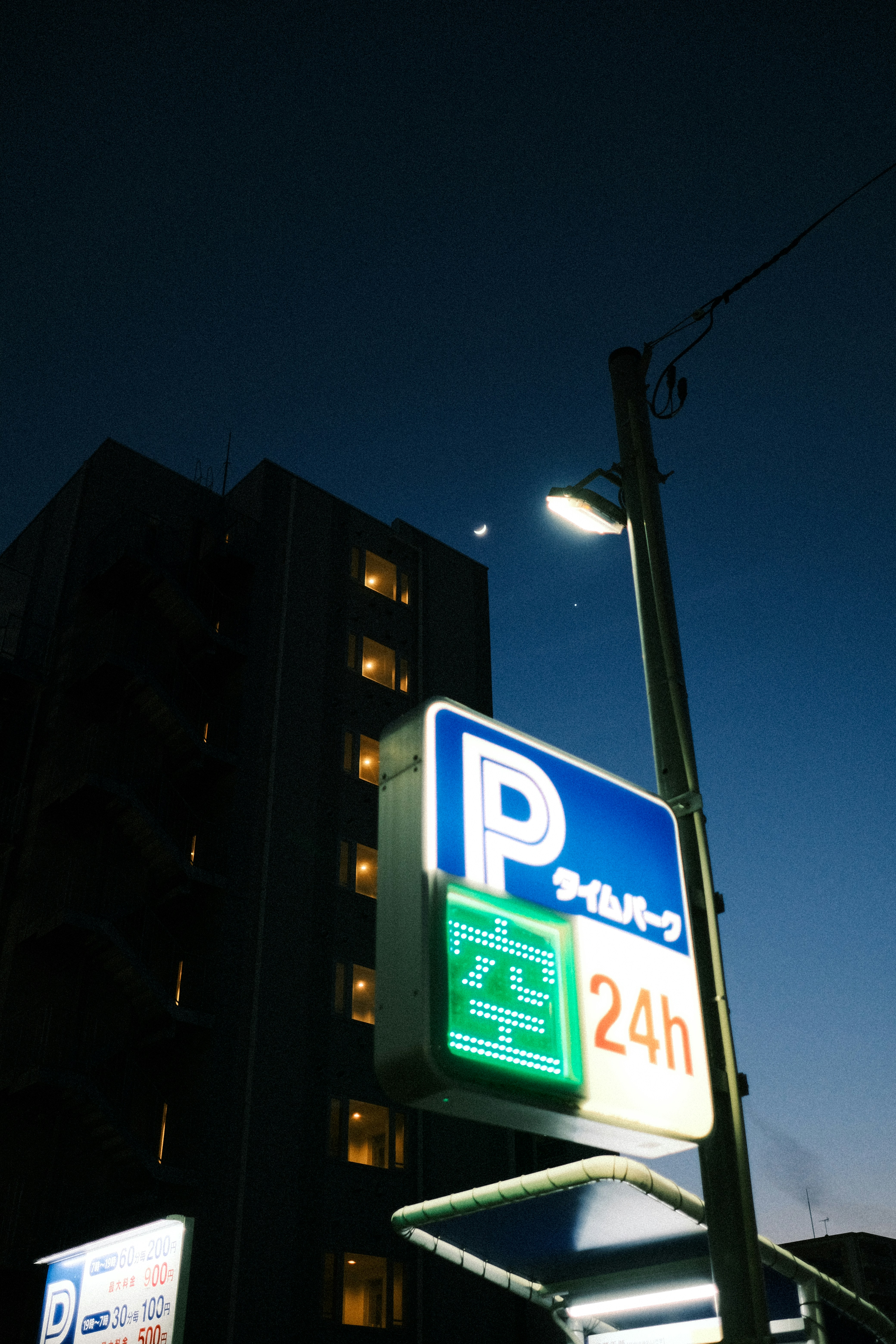 Street sign with parking information at dusk