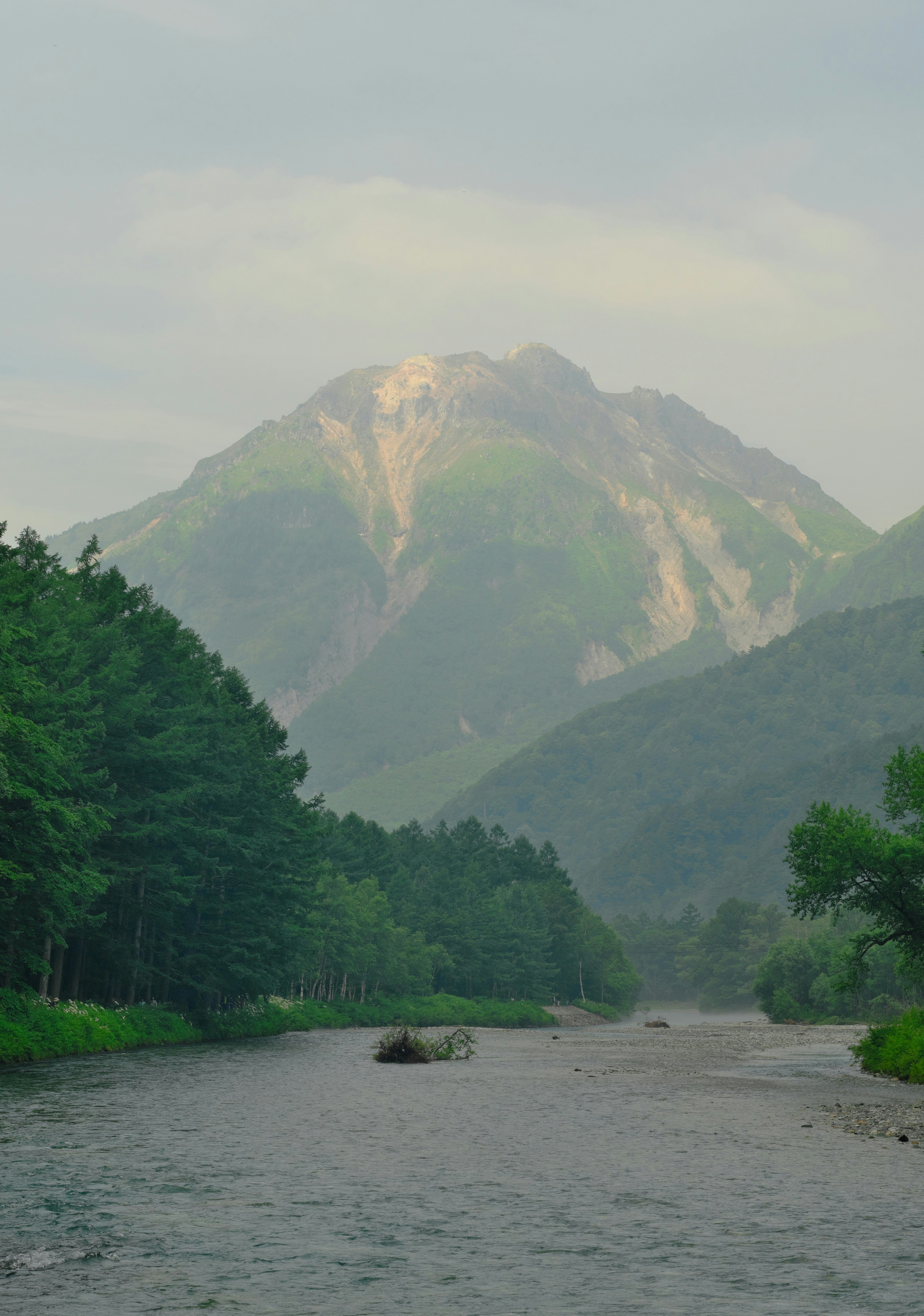 Misty mountain range with a river in the foreground.