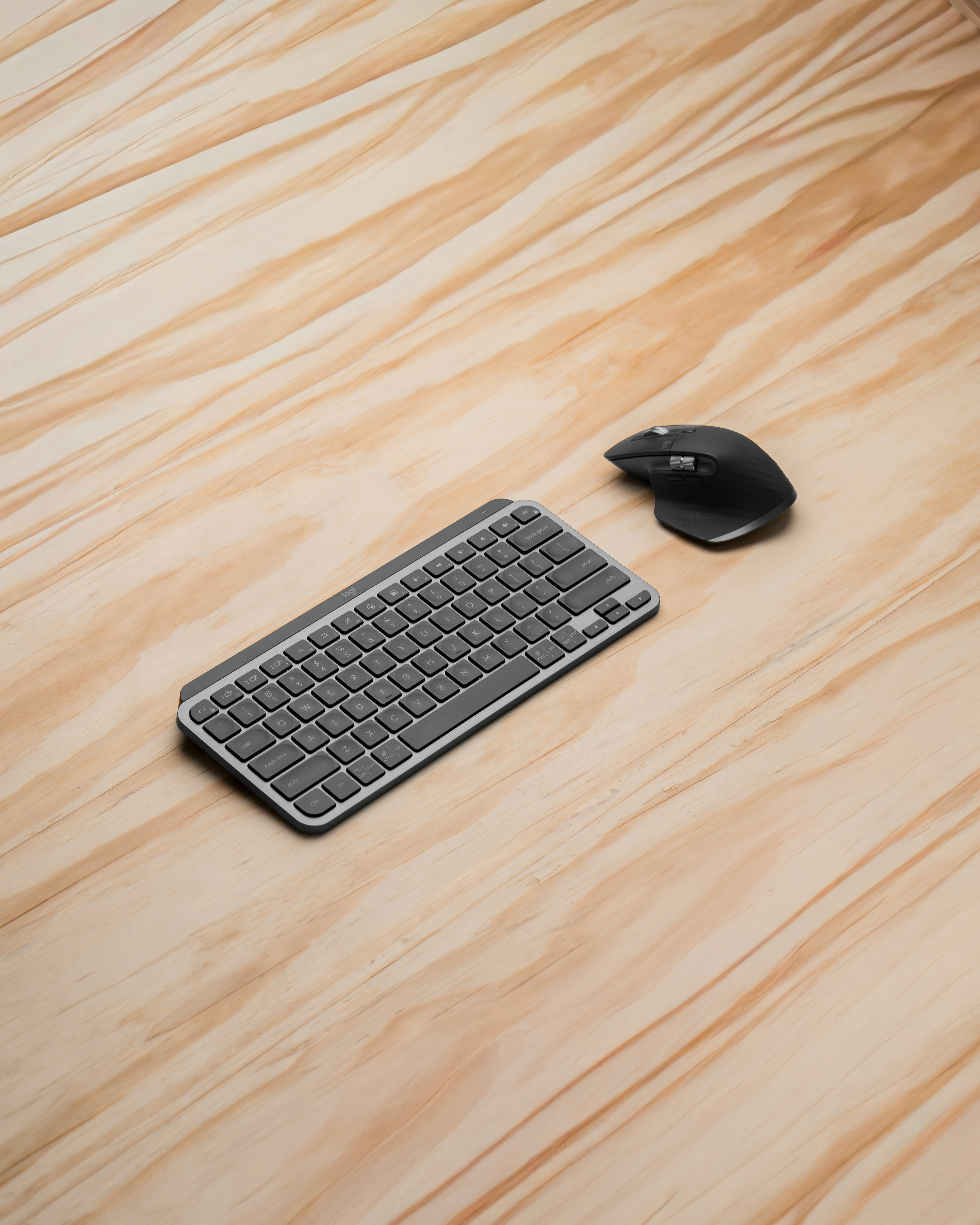 MX Master Combo. | Gray keyboard and mouse on a wooden surface