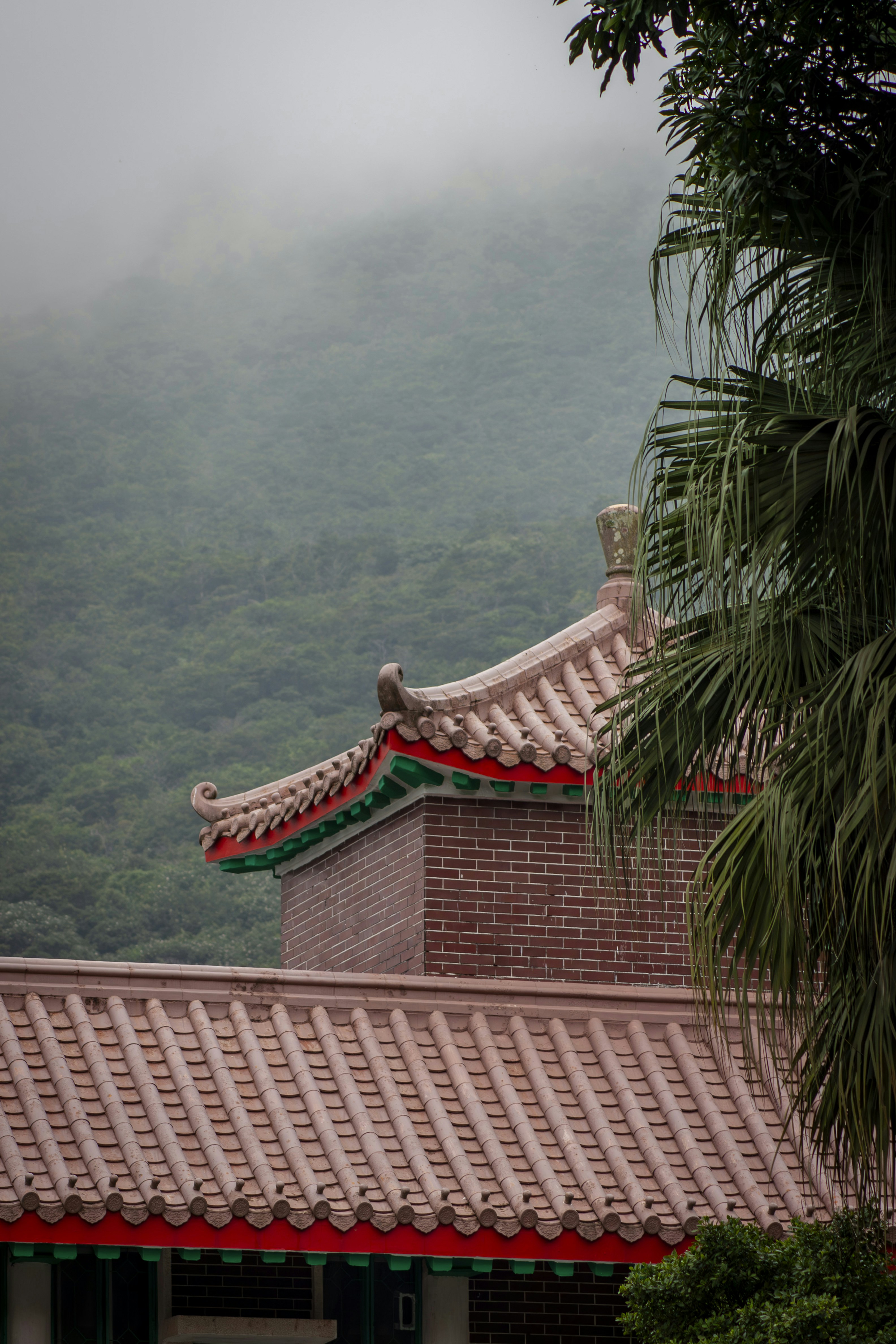 Traditional asian temple roof against misty mountains