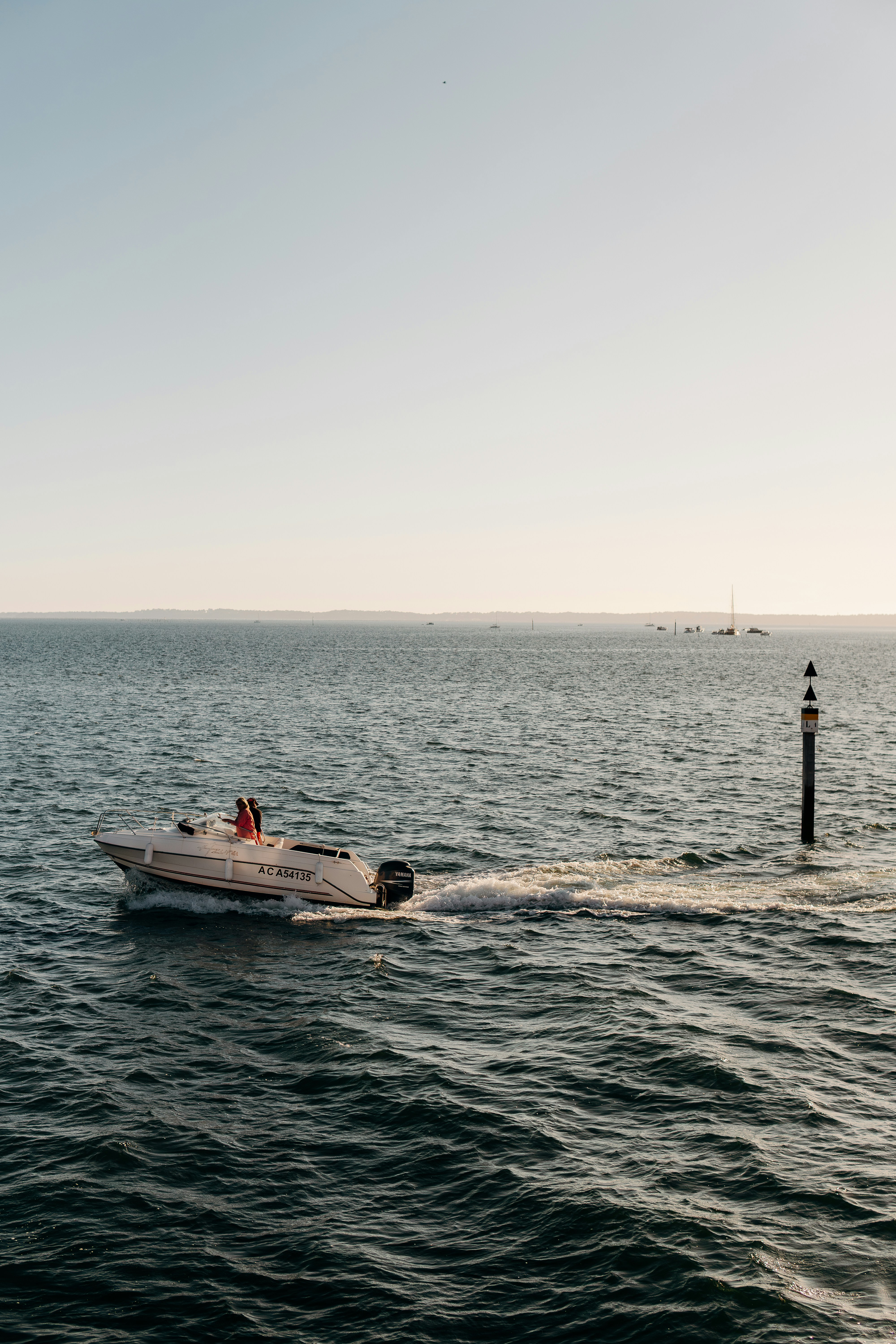 A white motorboat speeds across the water.
