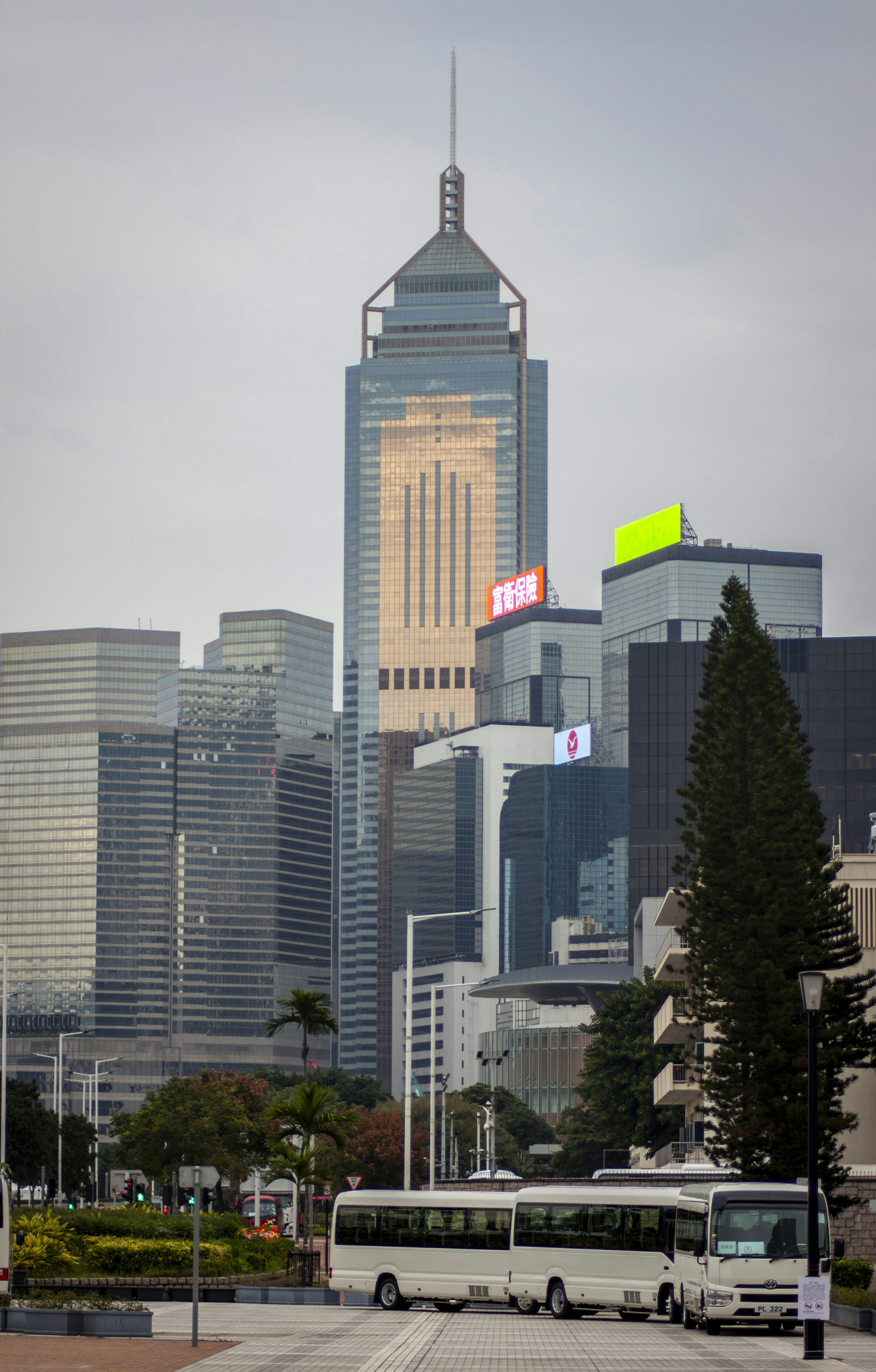 Modern skyscrapers and white buses in a city