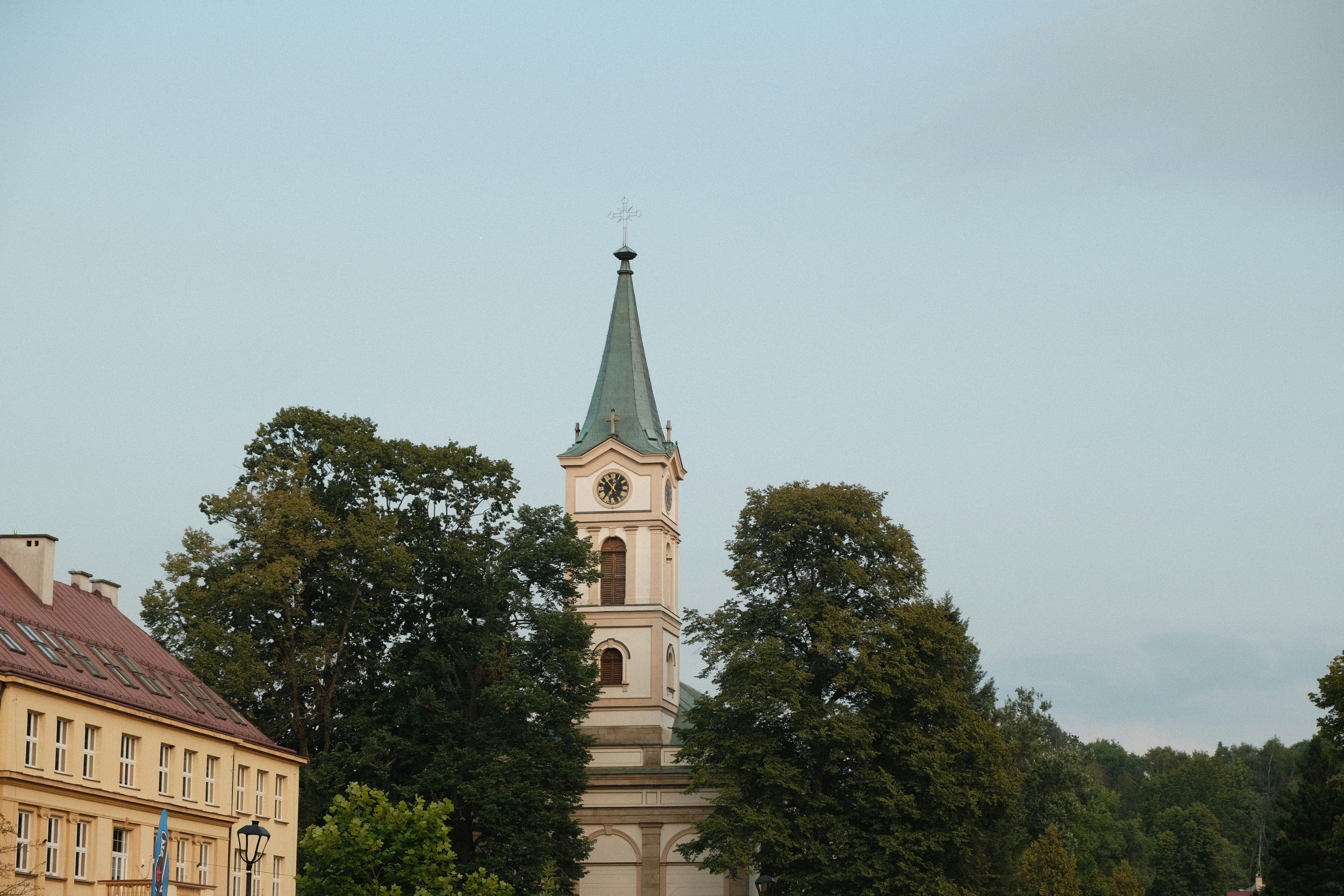 Church steeple with clock tower and trees