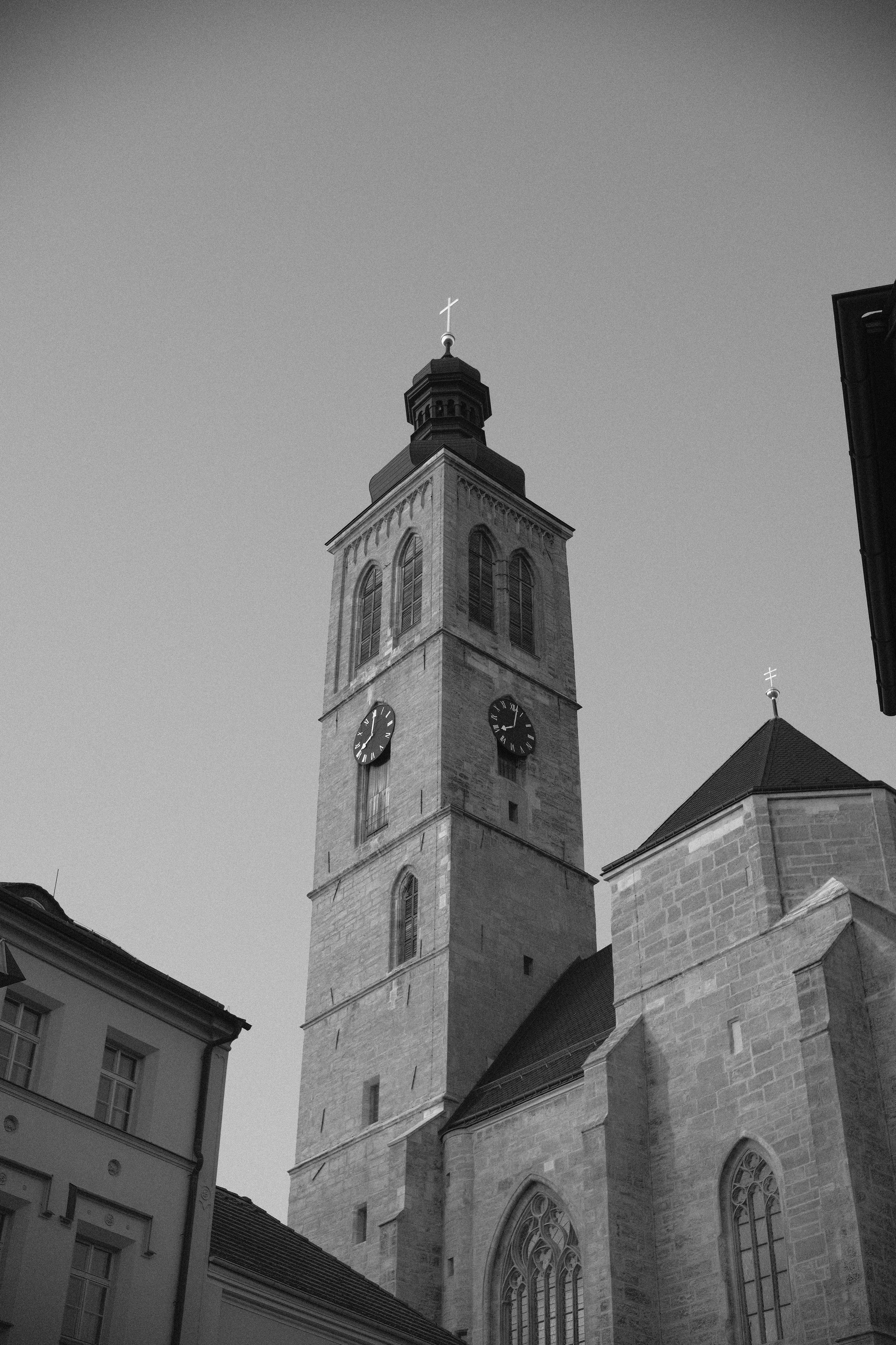 Stone church tower with clocks against clear sky