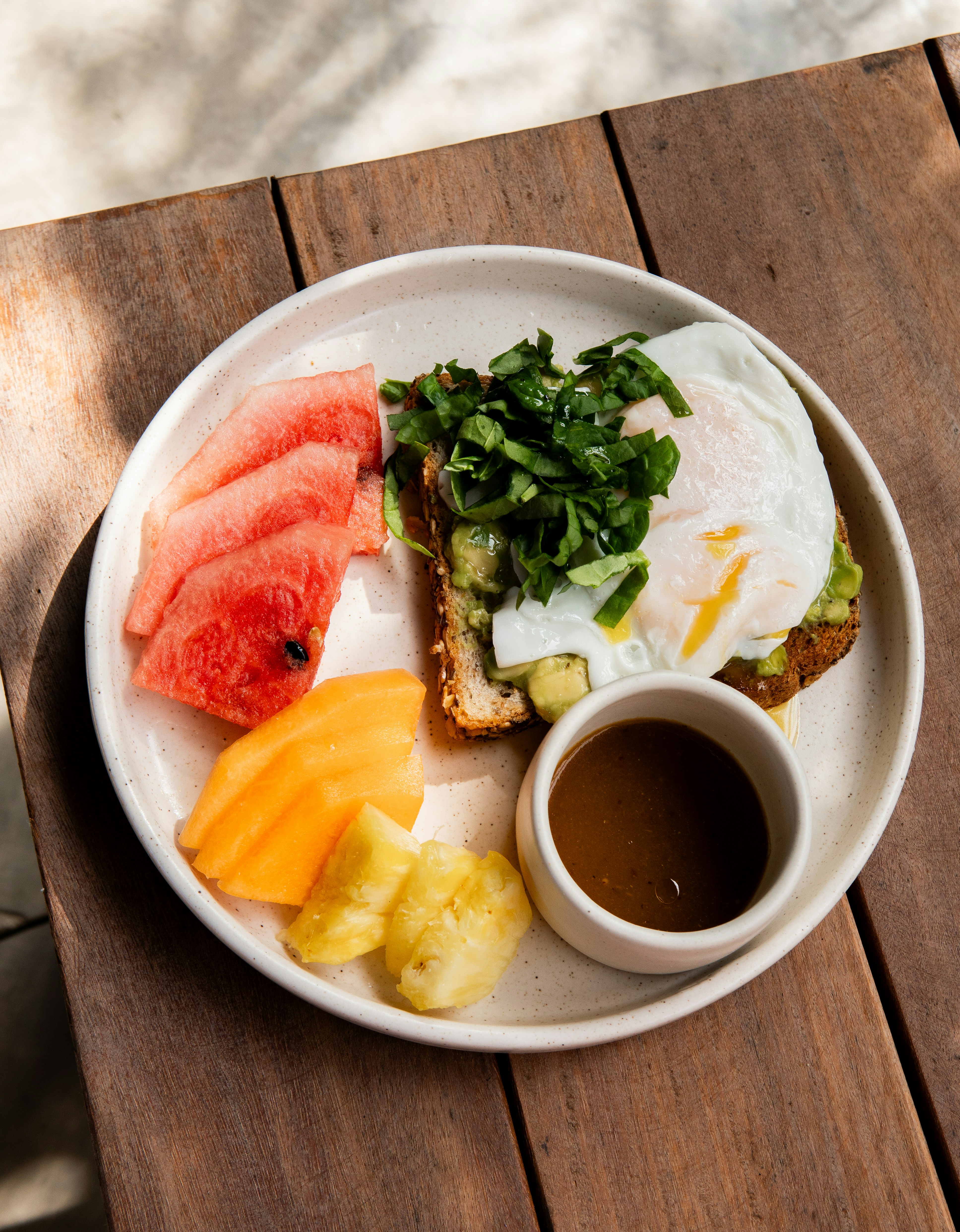 Herb-Crowned Poached Egg on Avocado Toast with a Bright Fruit Medley
