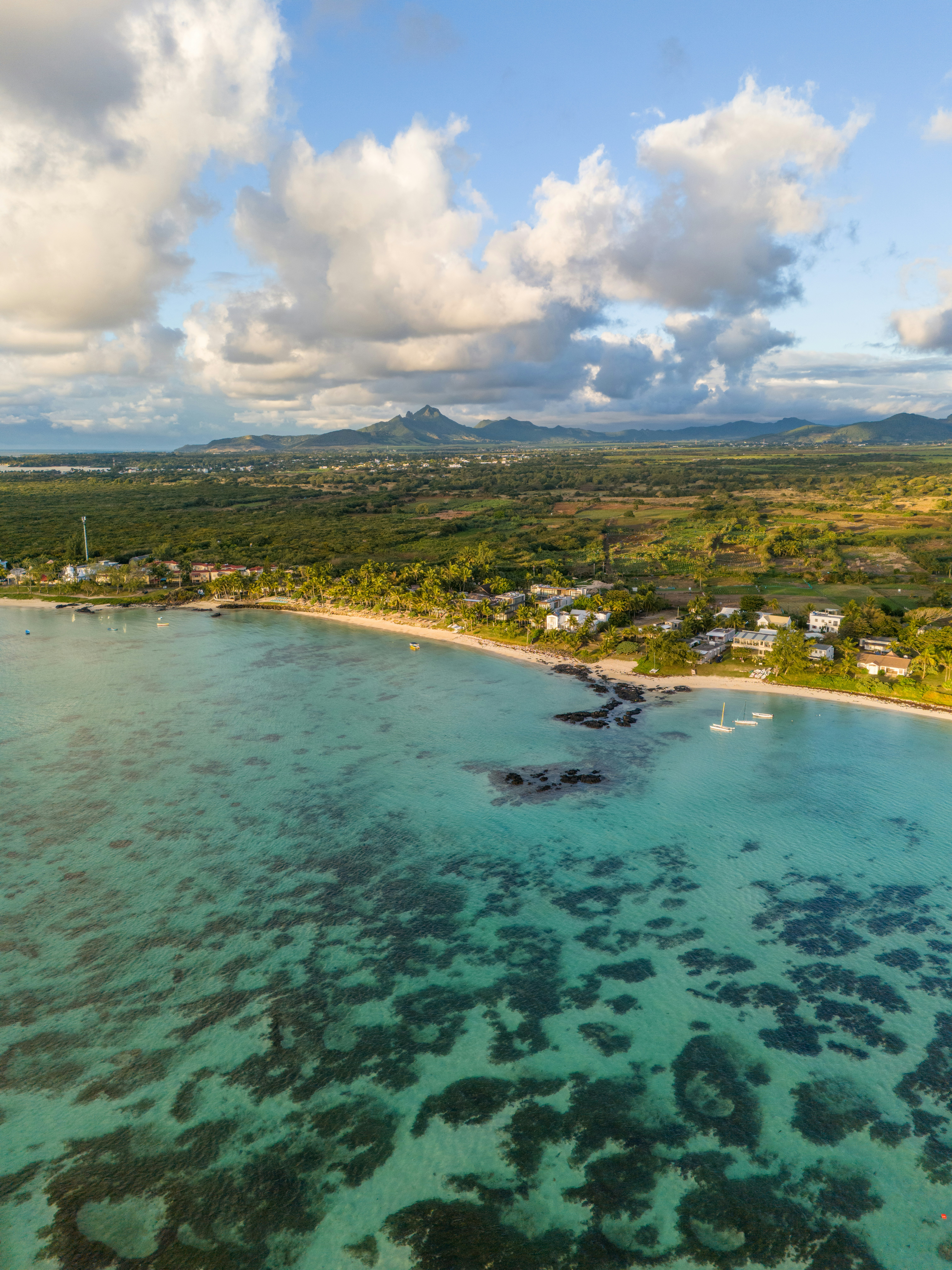 Aerial view of a tropical coastline with clear turquoise water.
