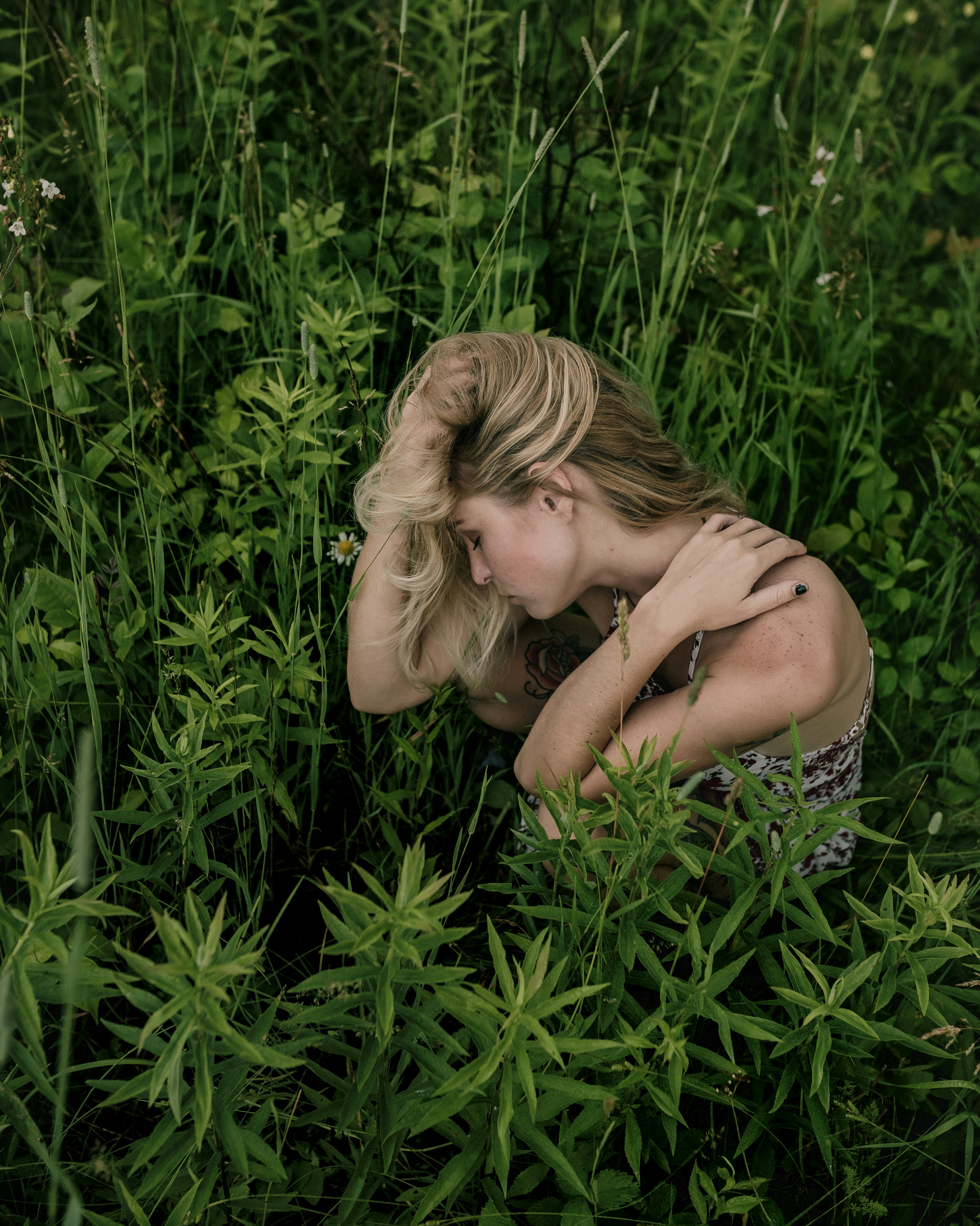 Self portrait taken in a field in Detroit, Michigan | Woman with blonde hair resting in tall green grass