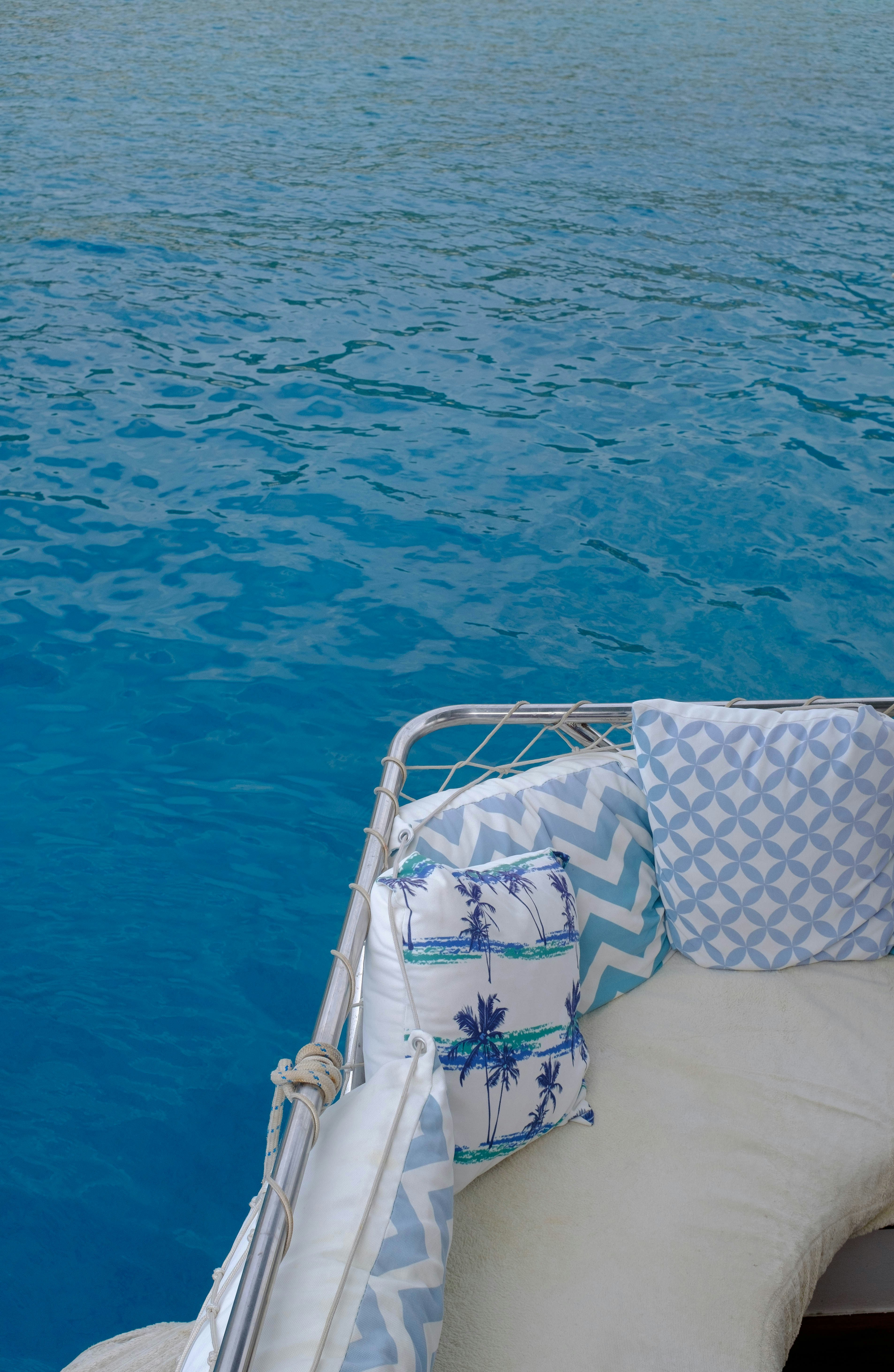 Cushions on a boat deck overlooking bright blue water
