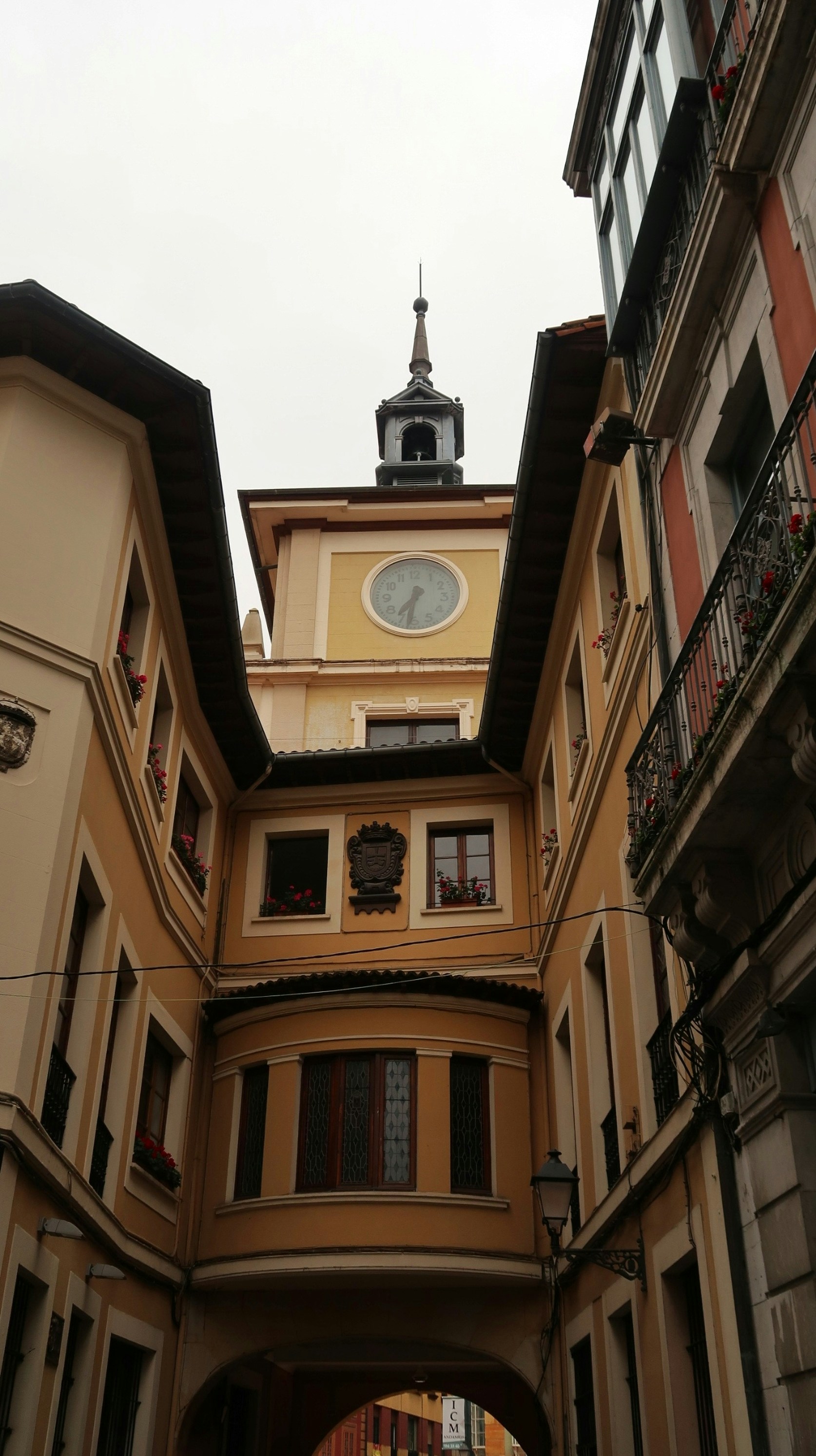 Tall clock tower between historic buildings