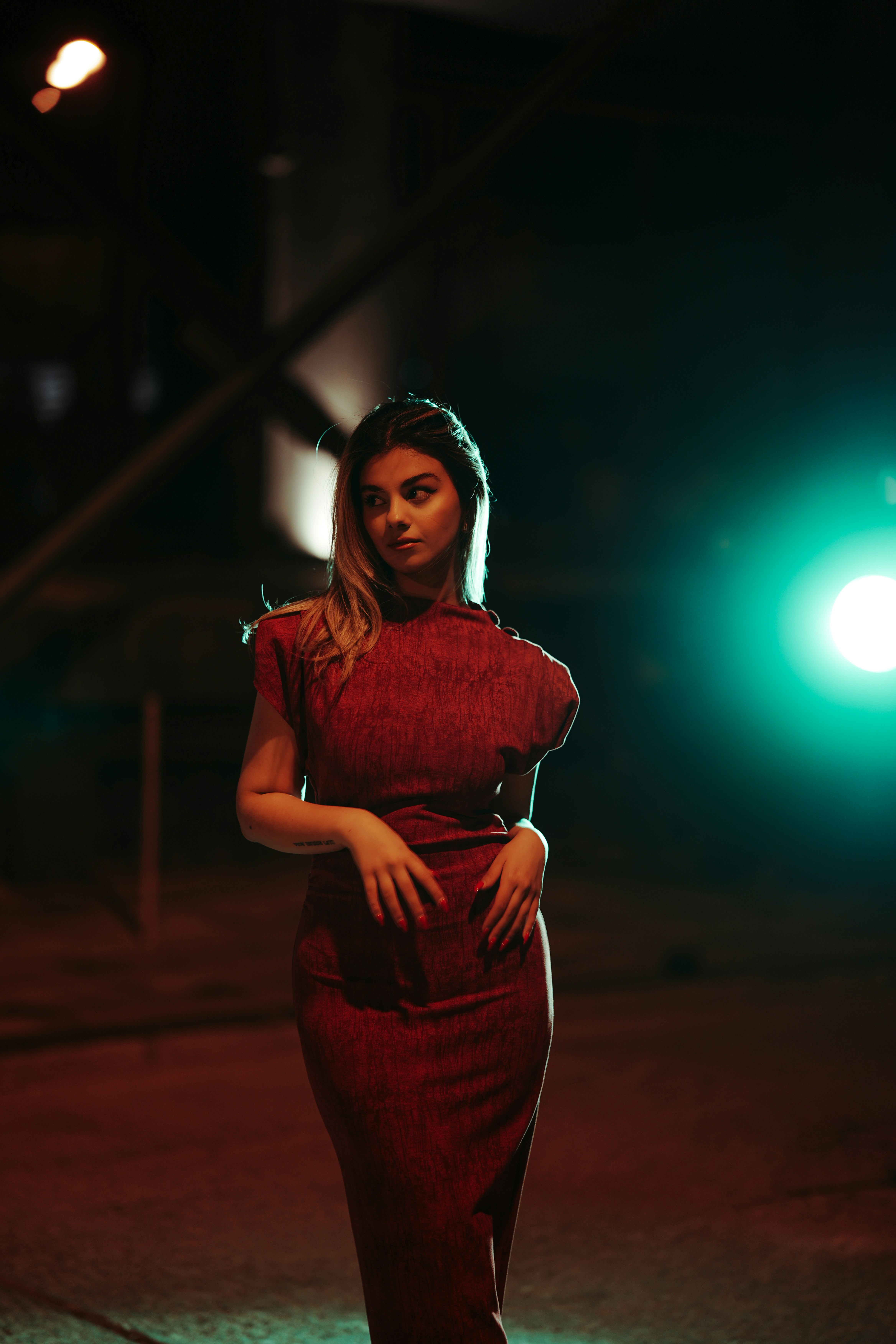 Woman in red dress illuminated by green light