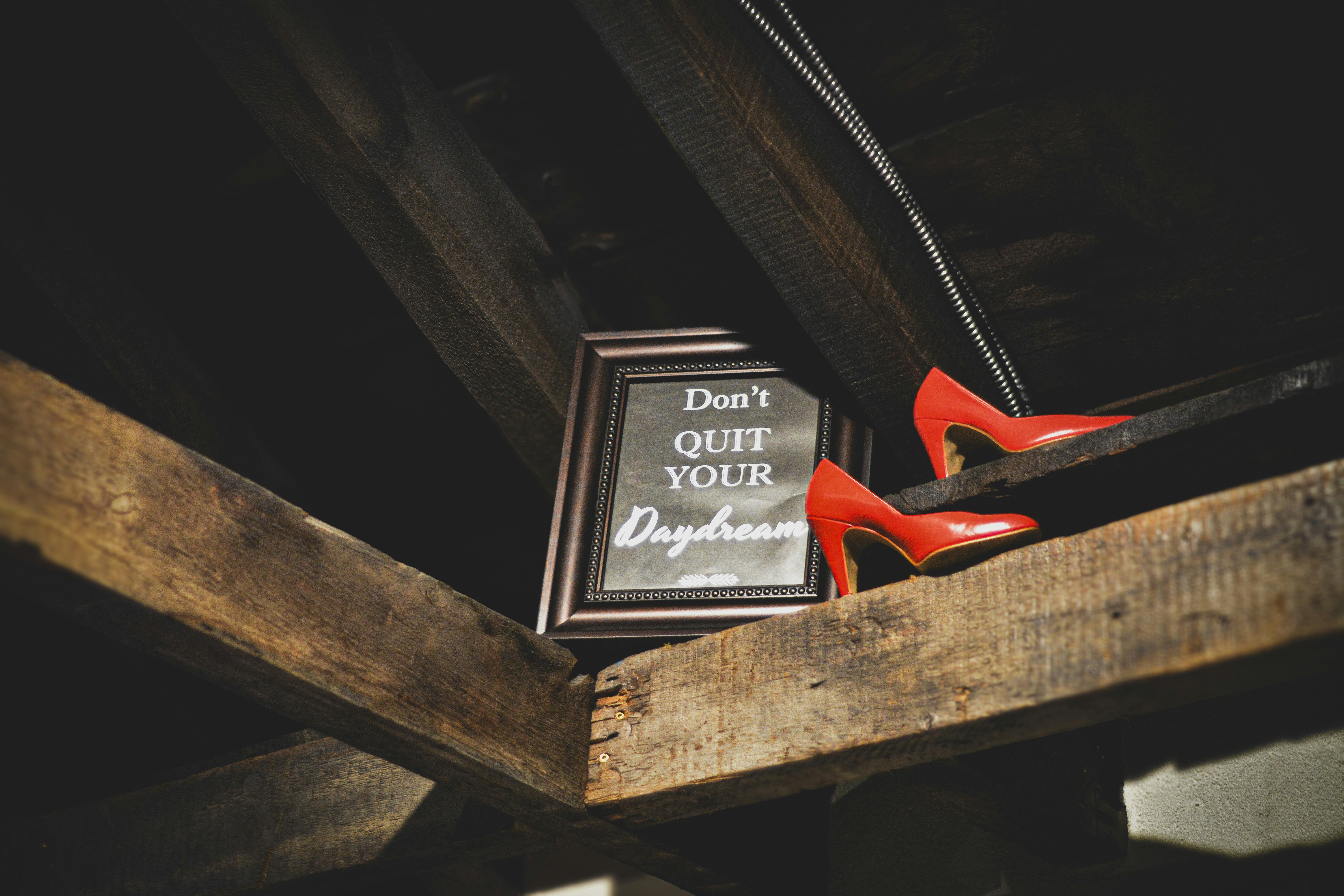 Red high heels and framed quote on wooden beams