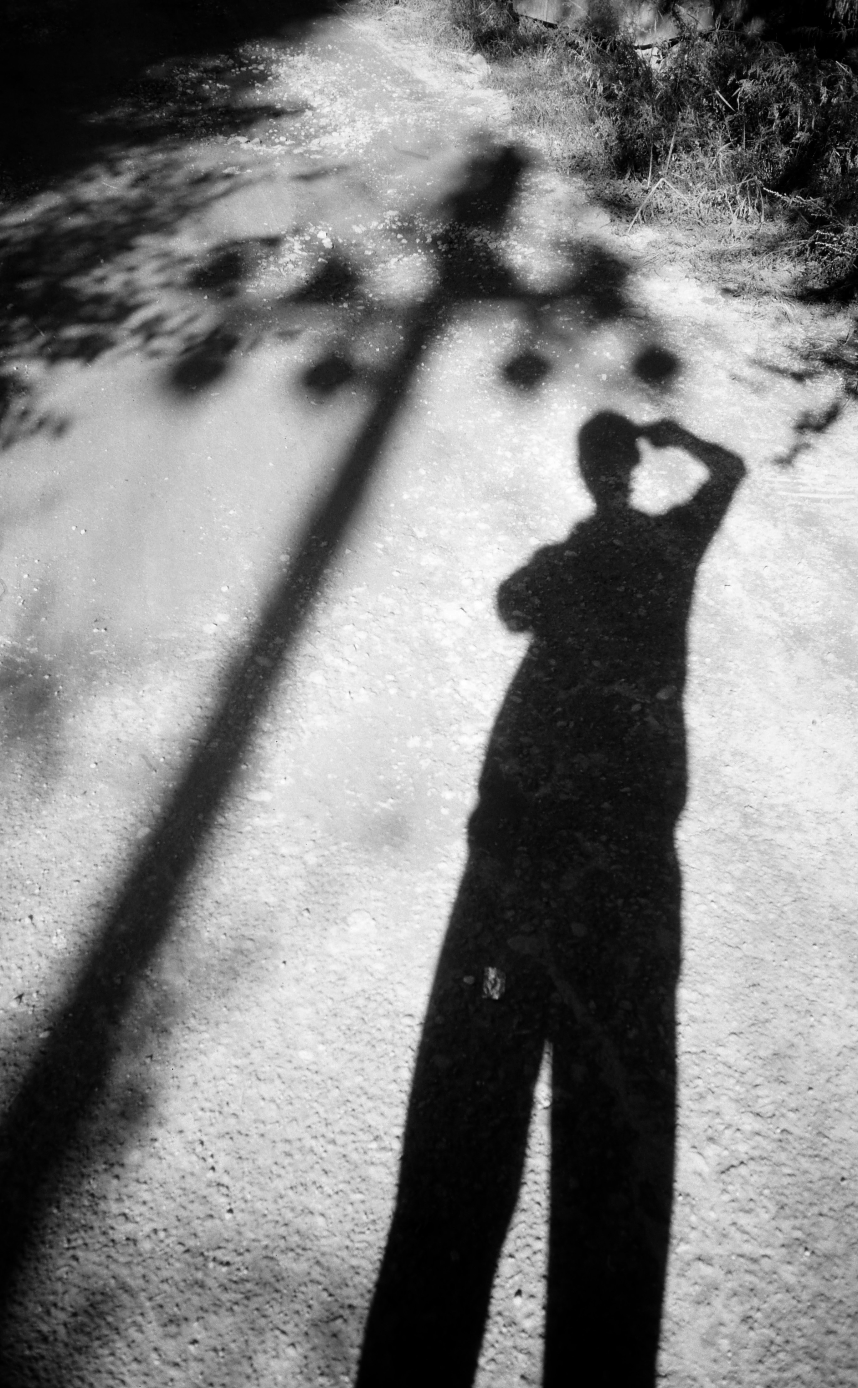 Shadow of a person and a street lamp on ground