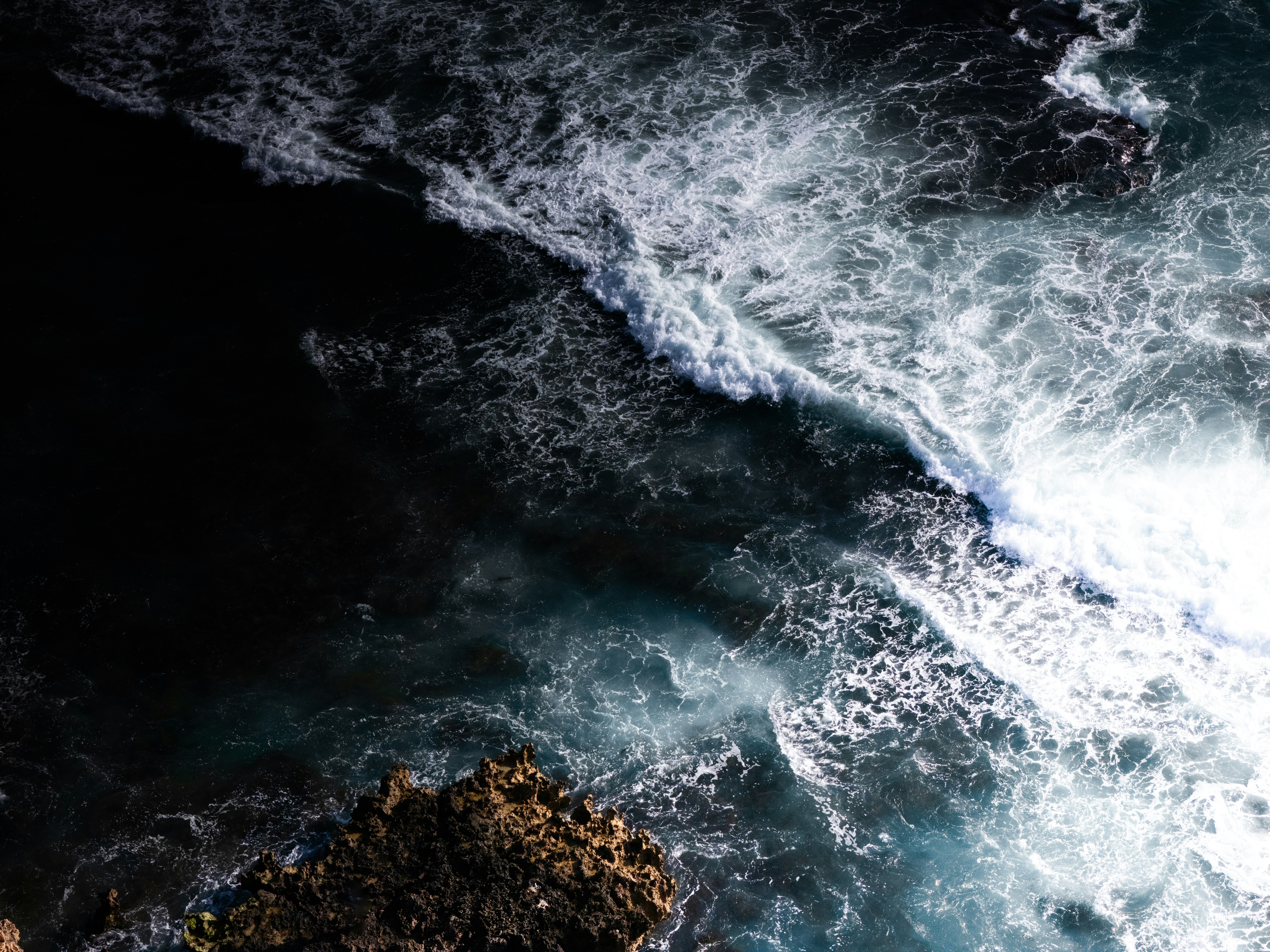 Dark ocean waves crash against rocky shore from above photo – Free Sea ...