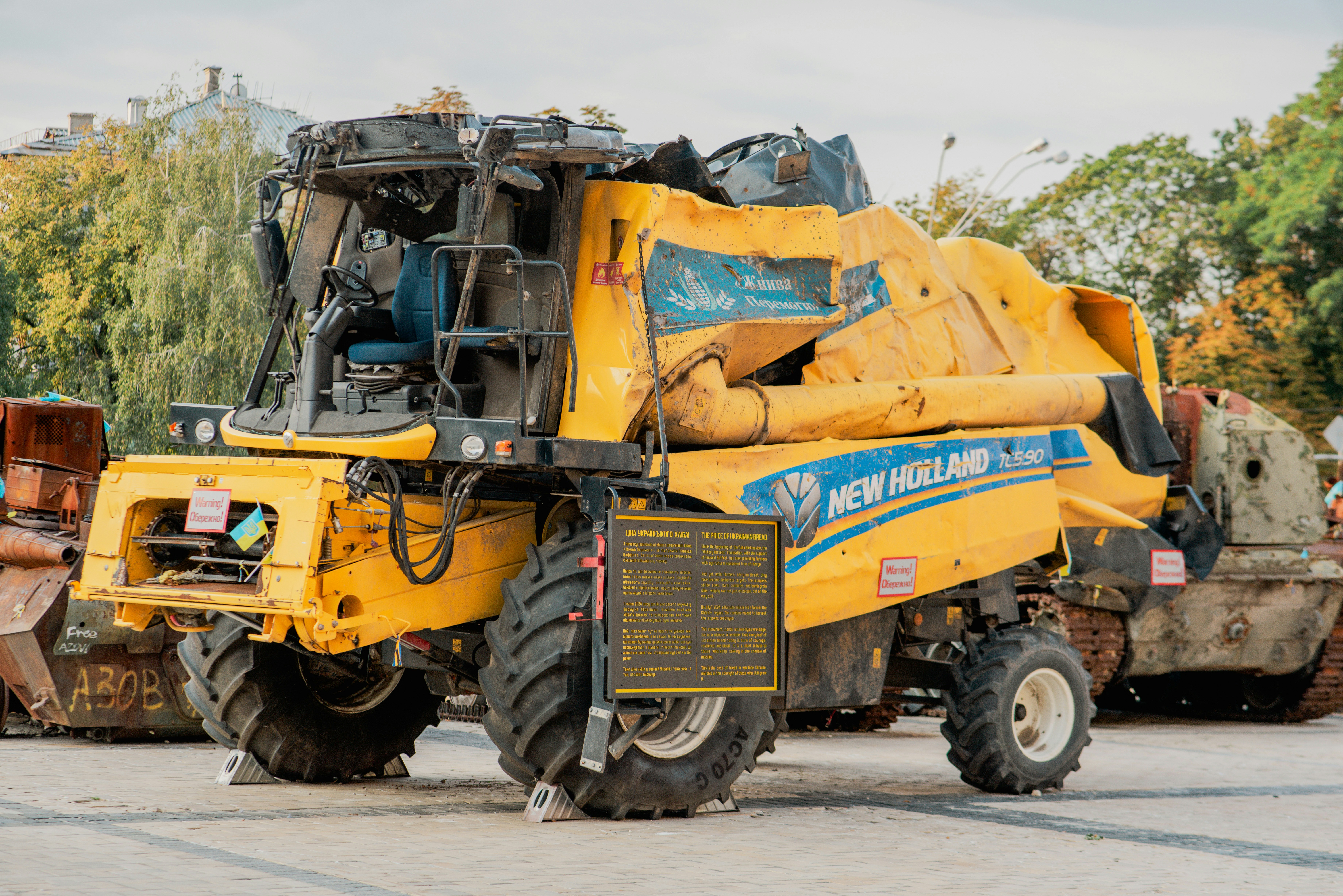 Sunlit Harvester: A Weathered New Holland Machine in an Outdoor Yard