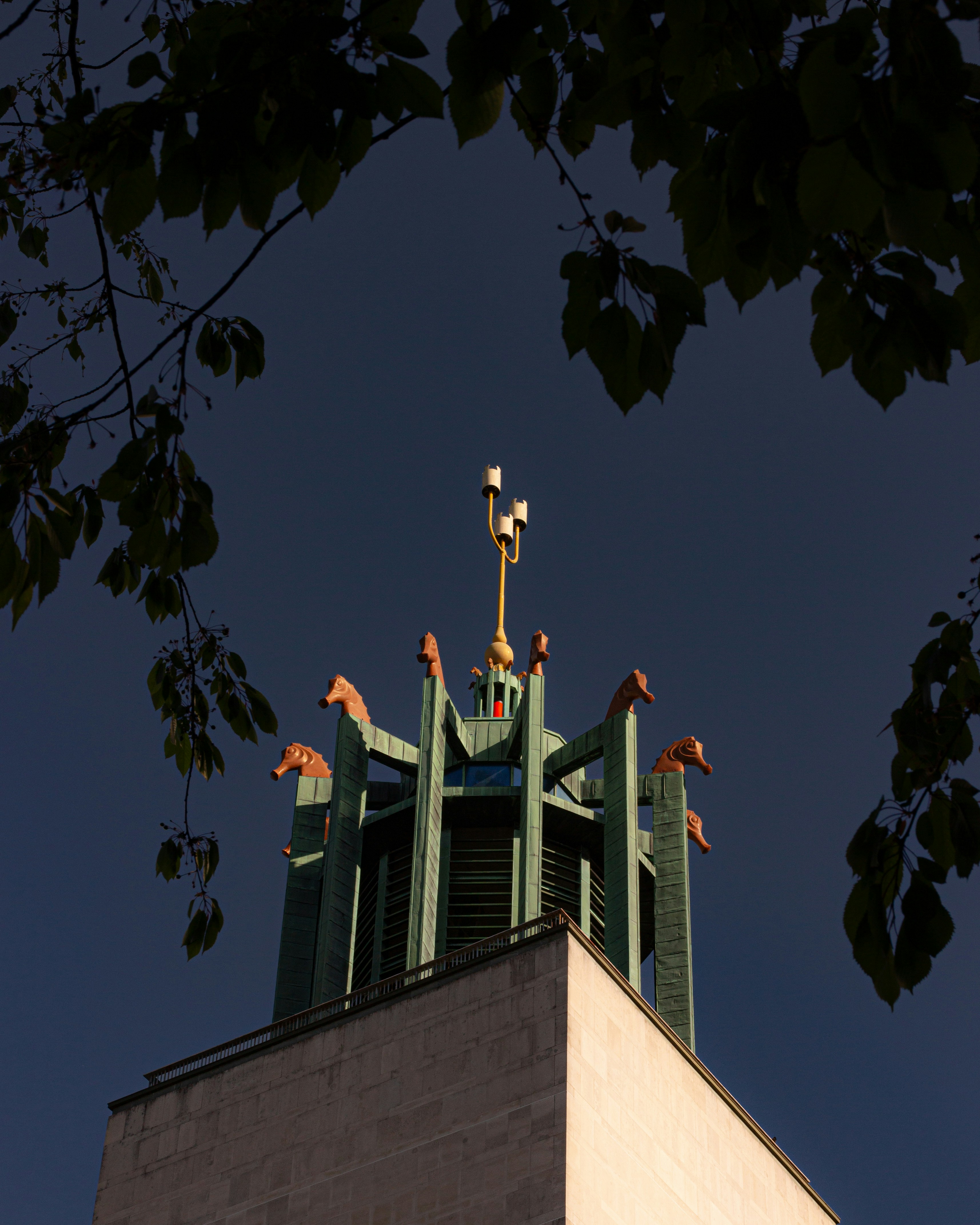 Building tower with ornate horse heads against sky