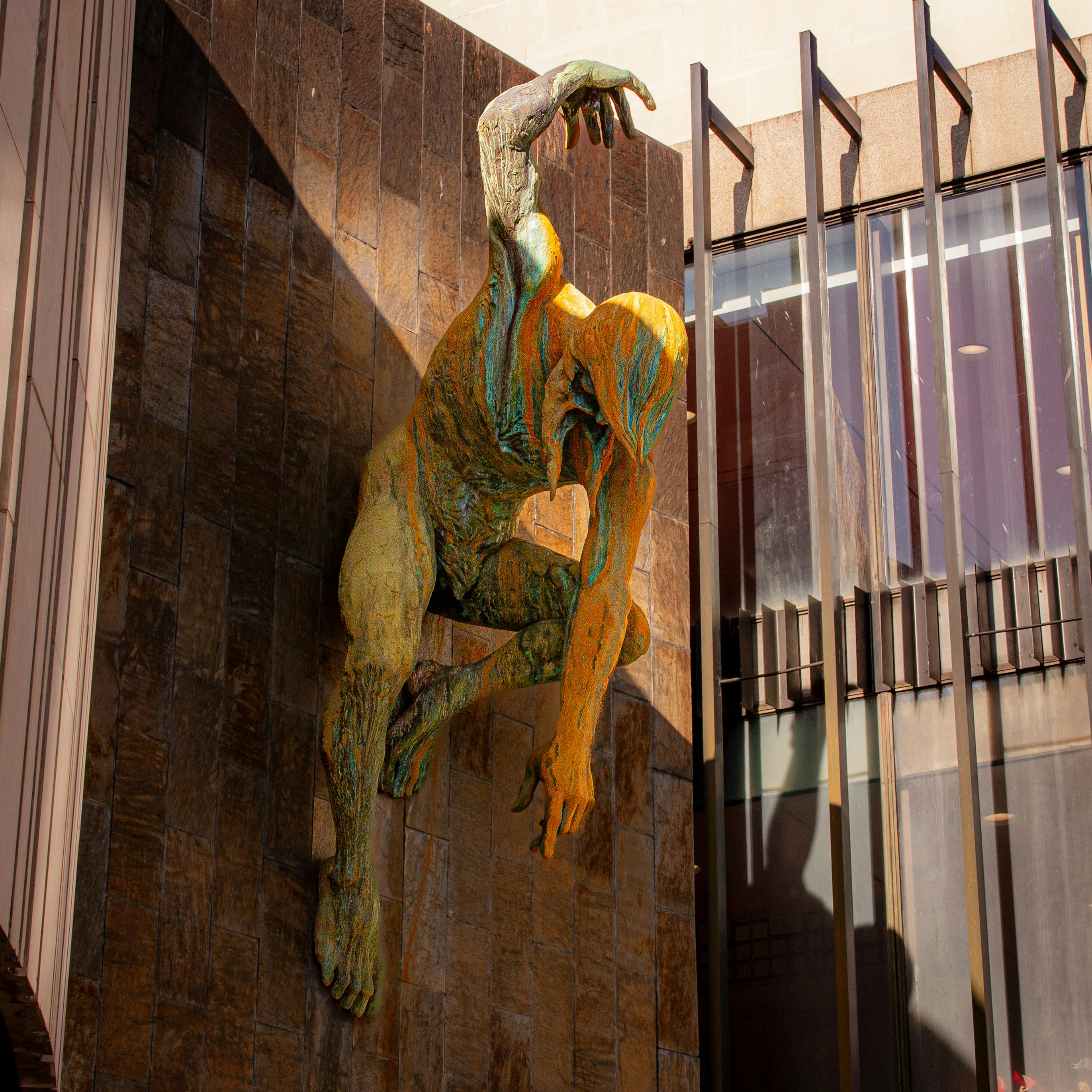 Sculpture of a man climbing on a building