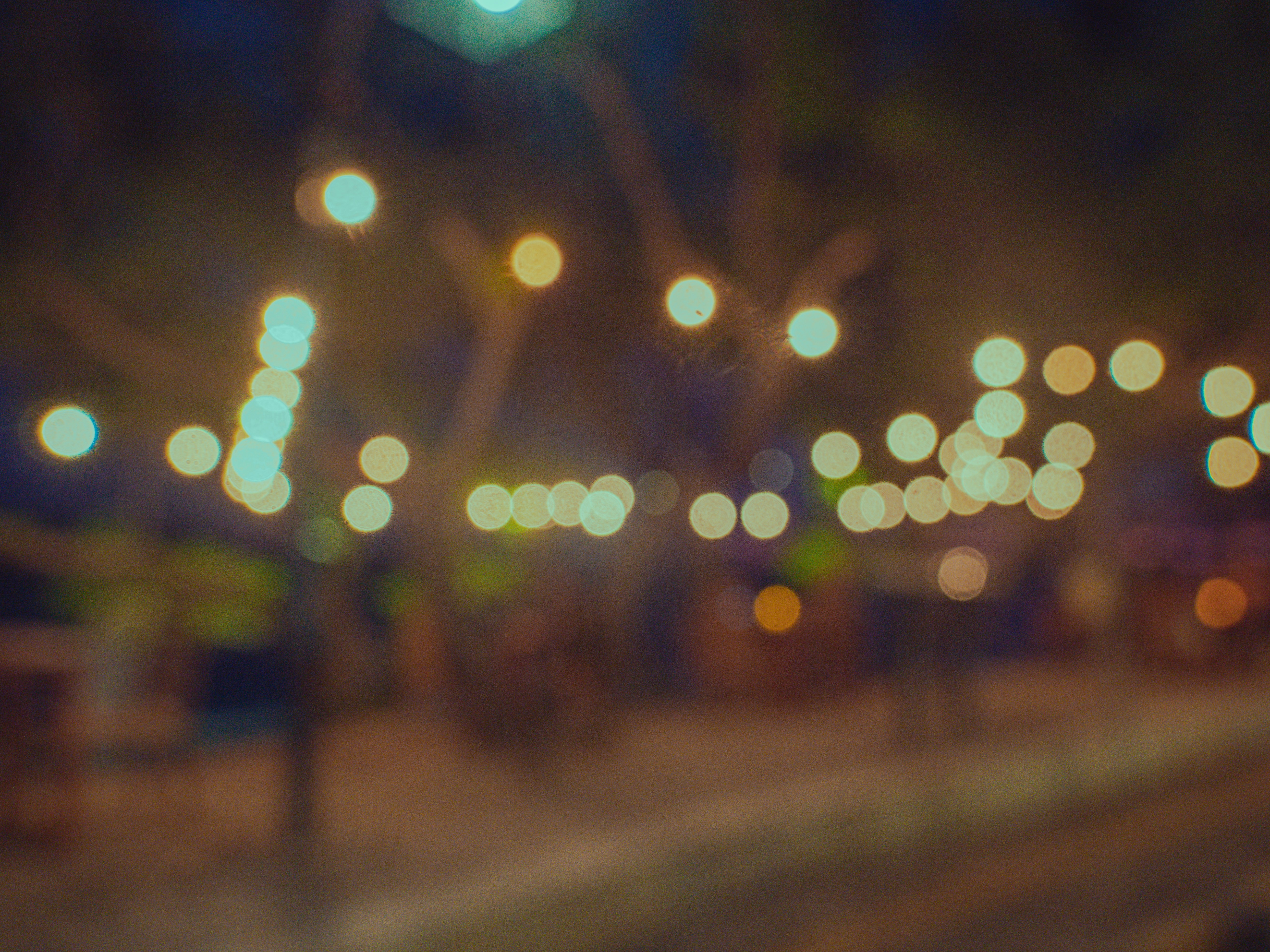 Blurred string lights illuminate a nighttime outdoor scene.