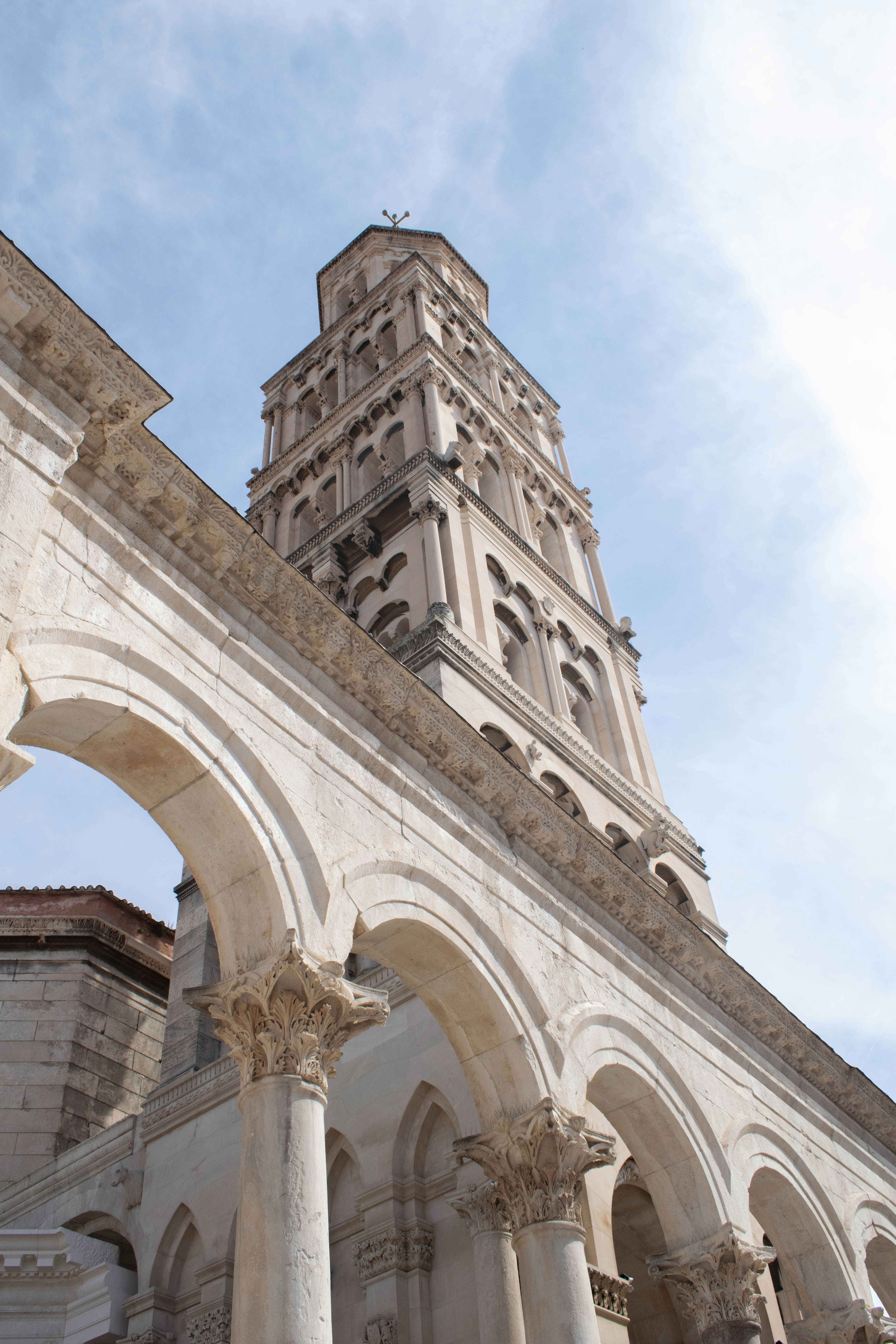 Stone streets, salty air, endless views. | Ancient stone arches with a tall tower against sky