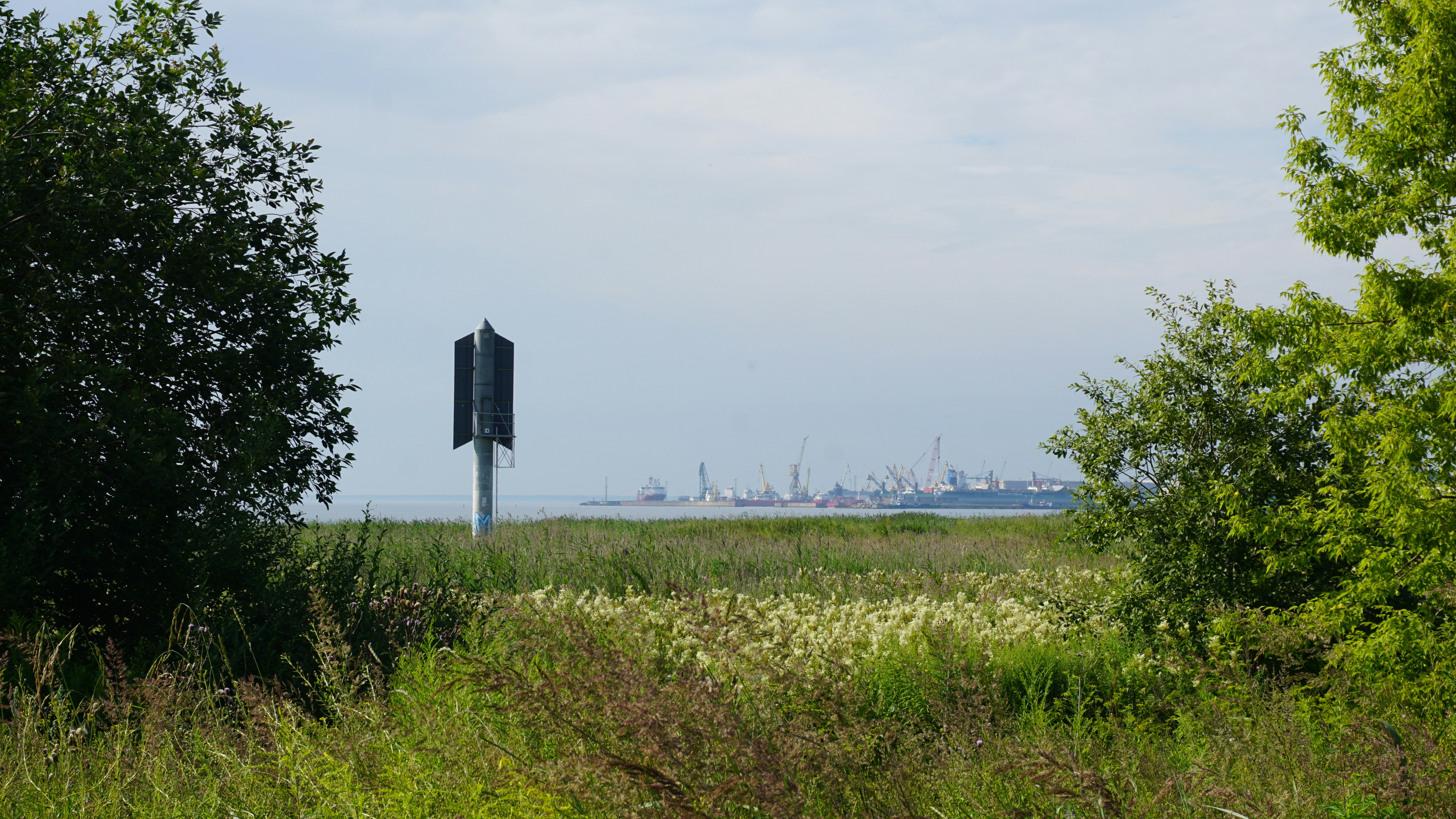 Distant industrial complex across a body of water.