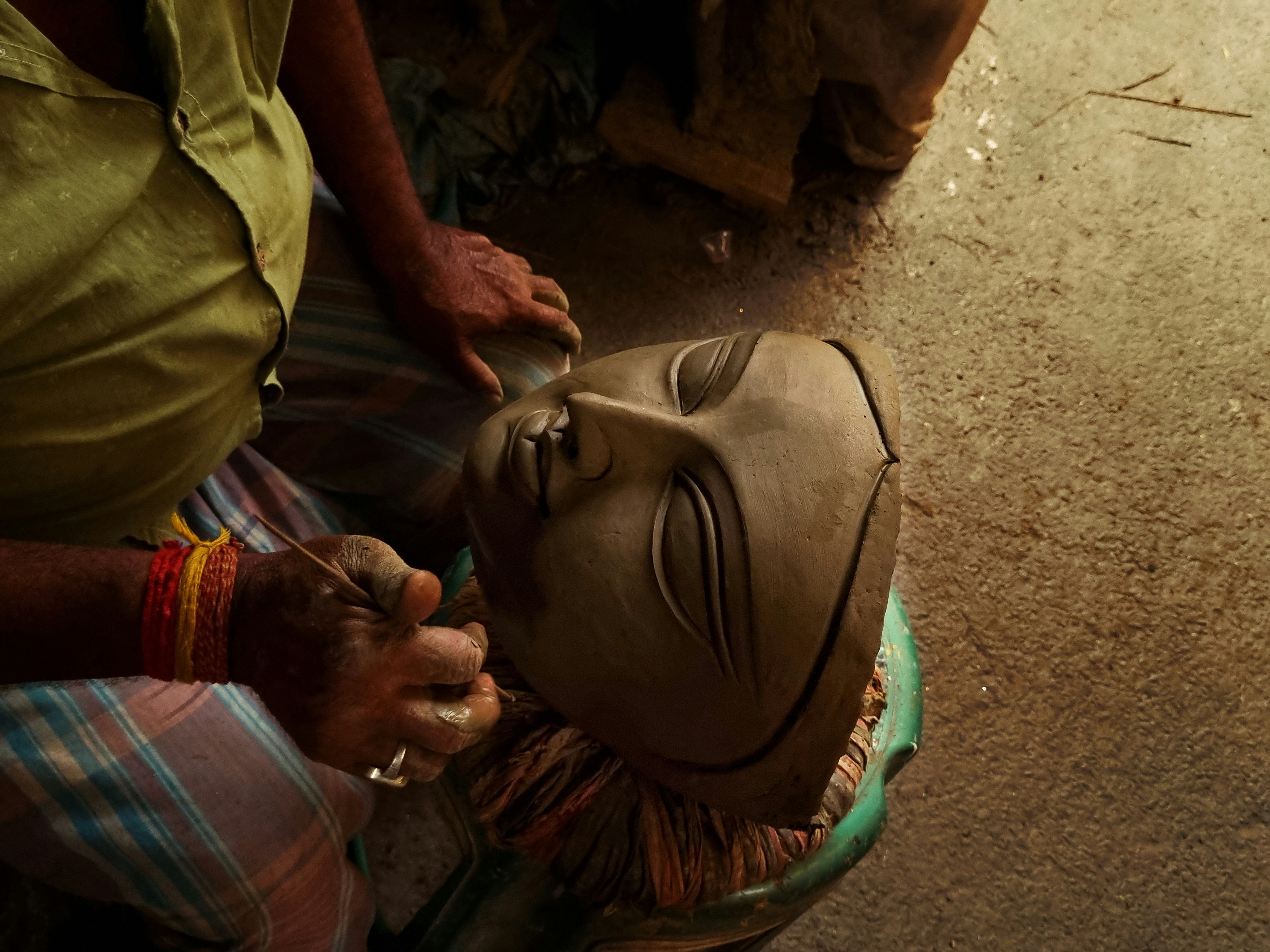 Mask in the Dust: Hands Shaping a Serene Face