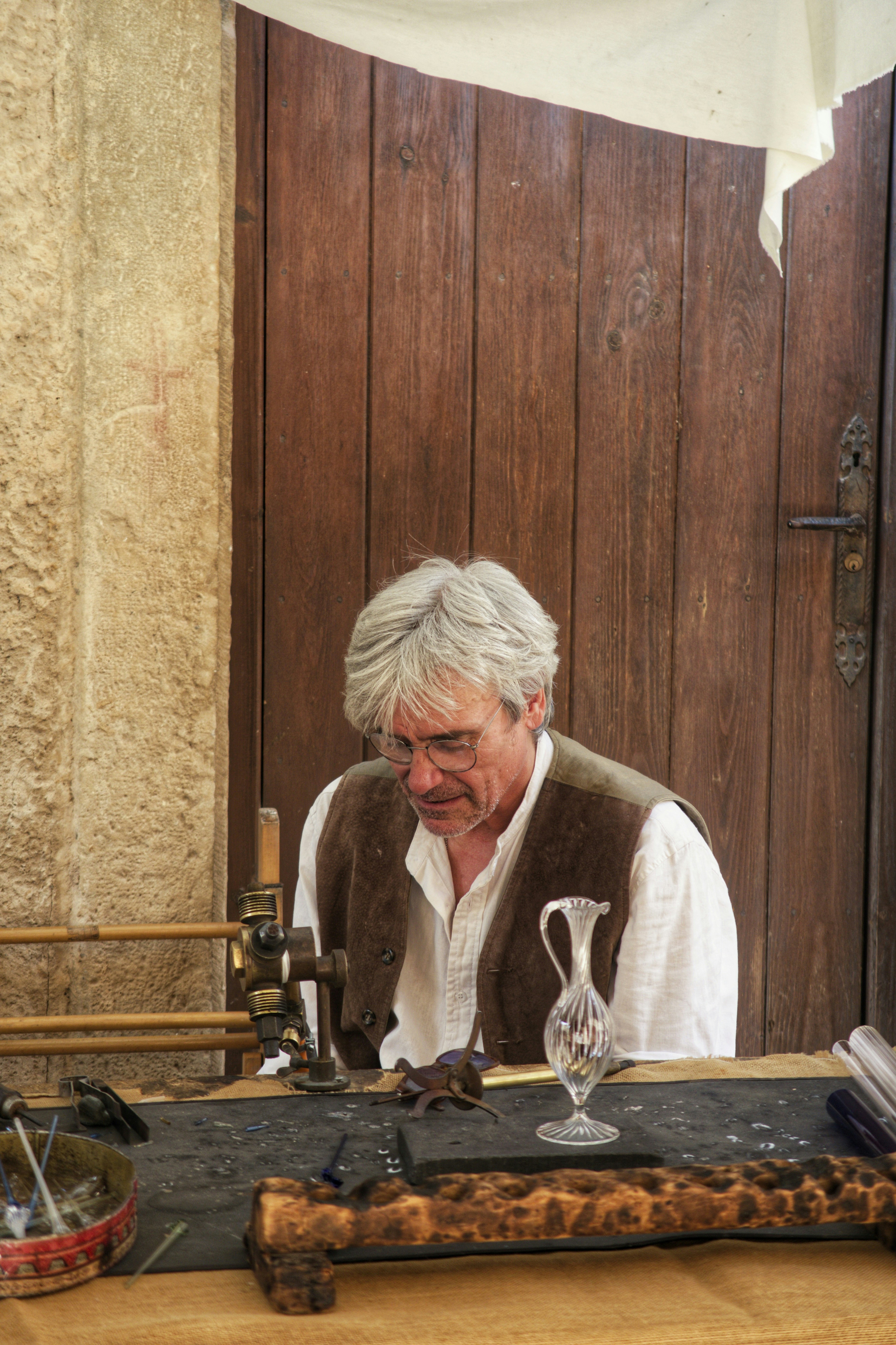 Man working on glassblowing with wooden background