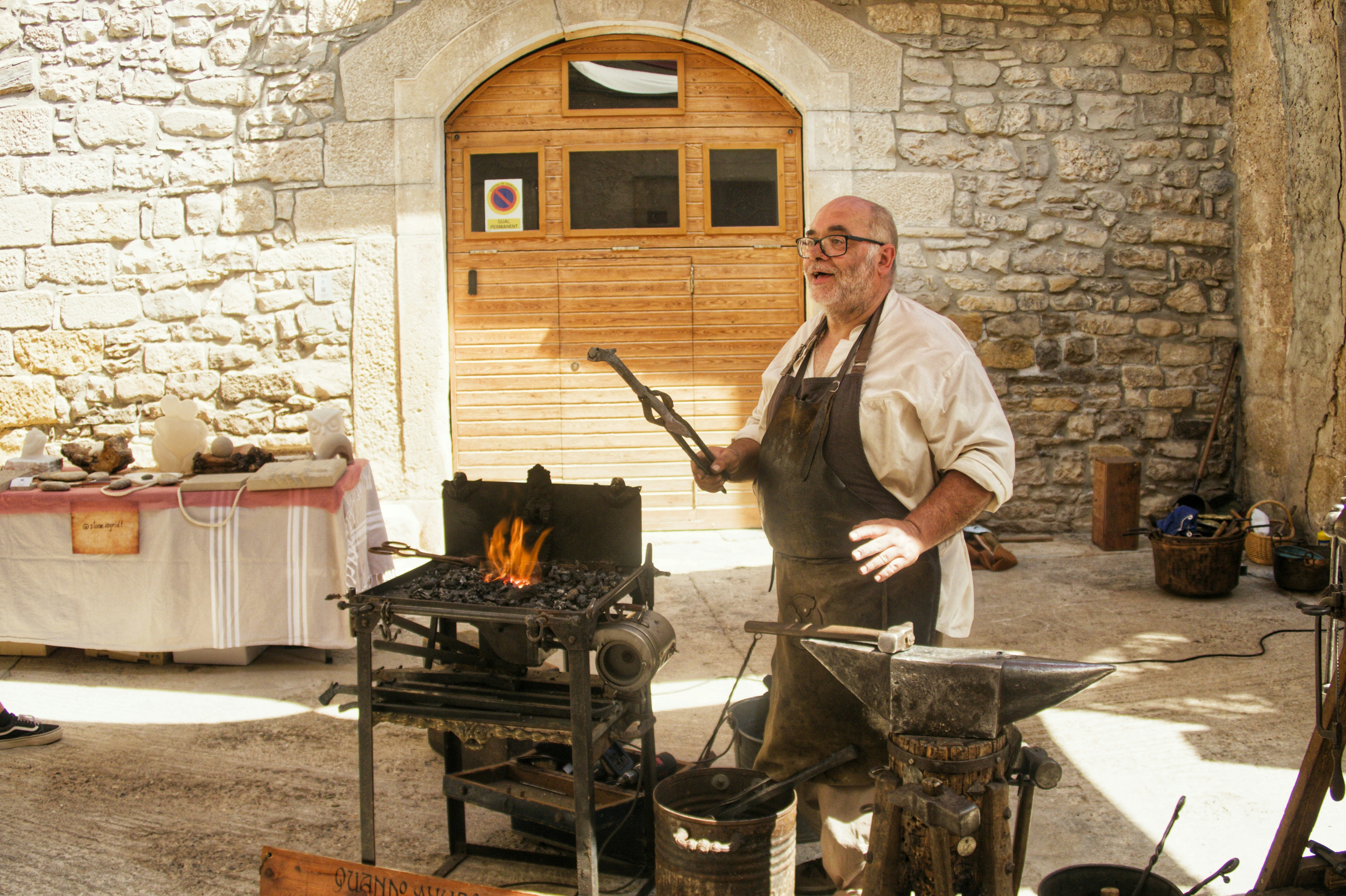 Blacksmith working at a forge with tools and anvil