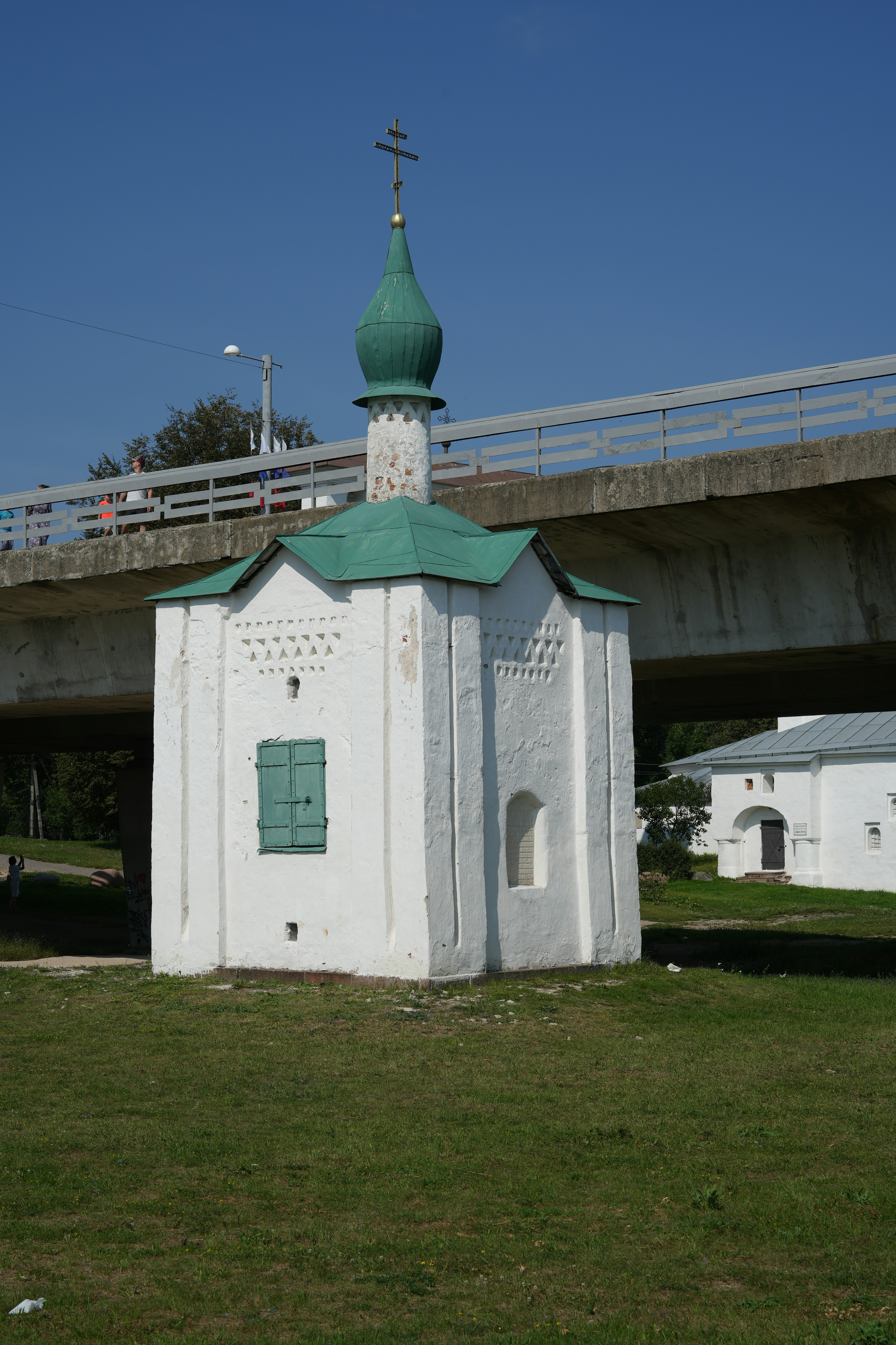 Chapel of Saint Anastasia | Small white chapel with green roof under bridge