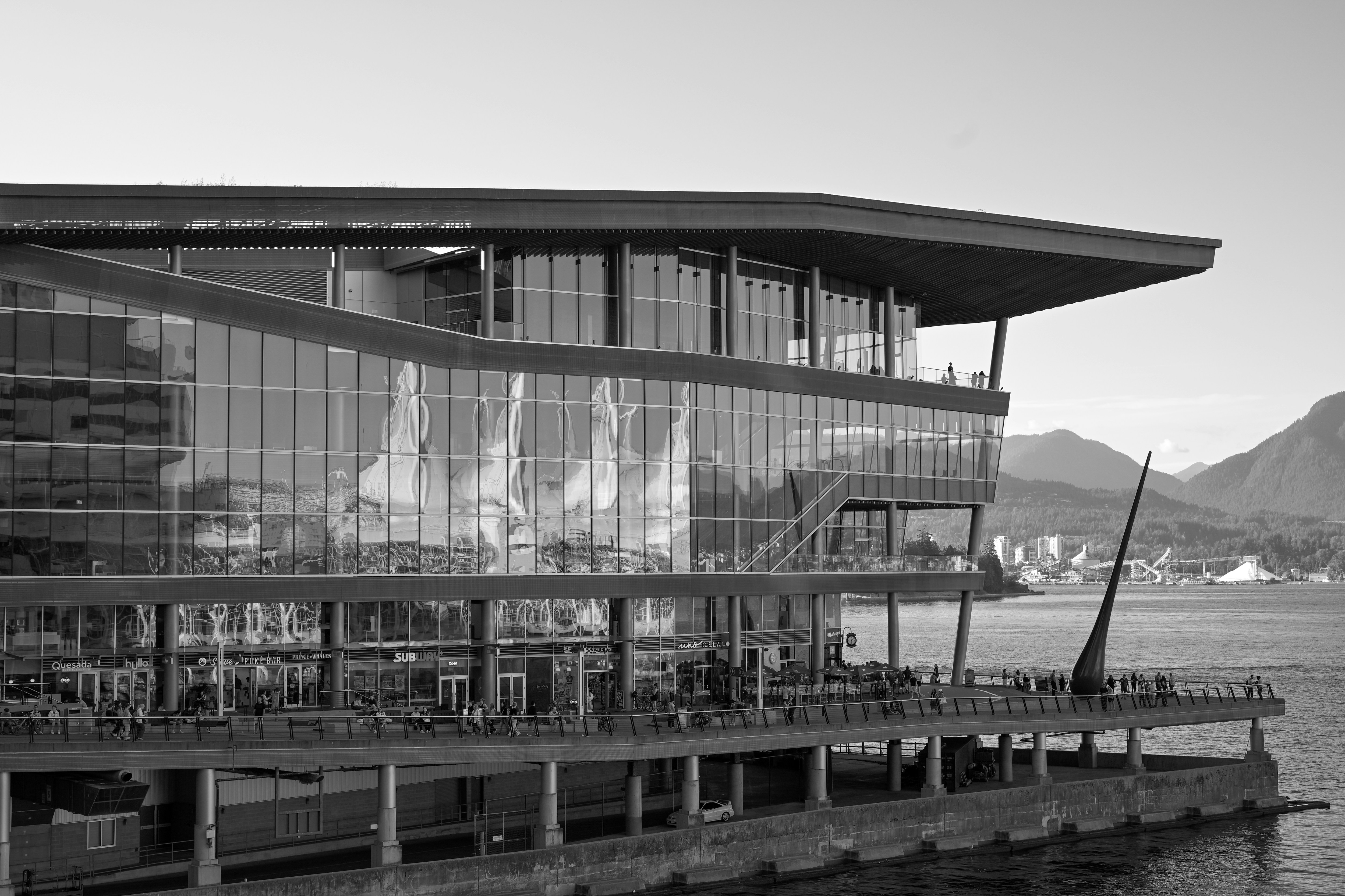 Architectural marvel with large glass facades reflecting the surrounding landscape, showcasing a blend of nature and modern design.