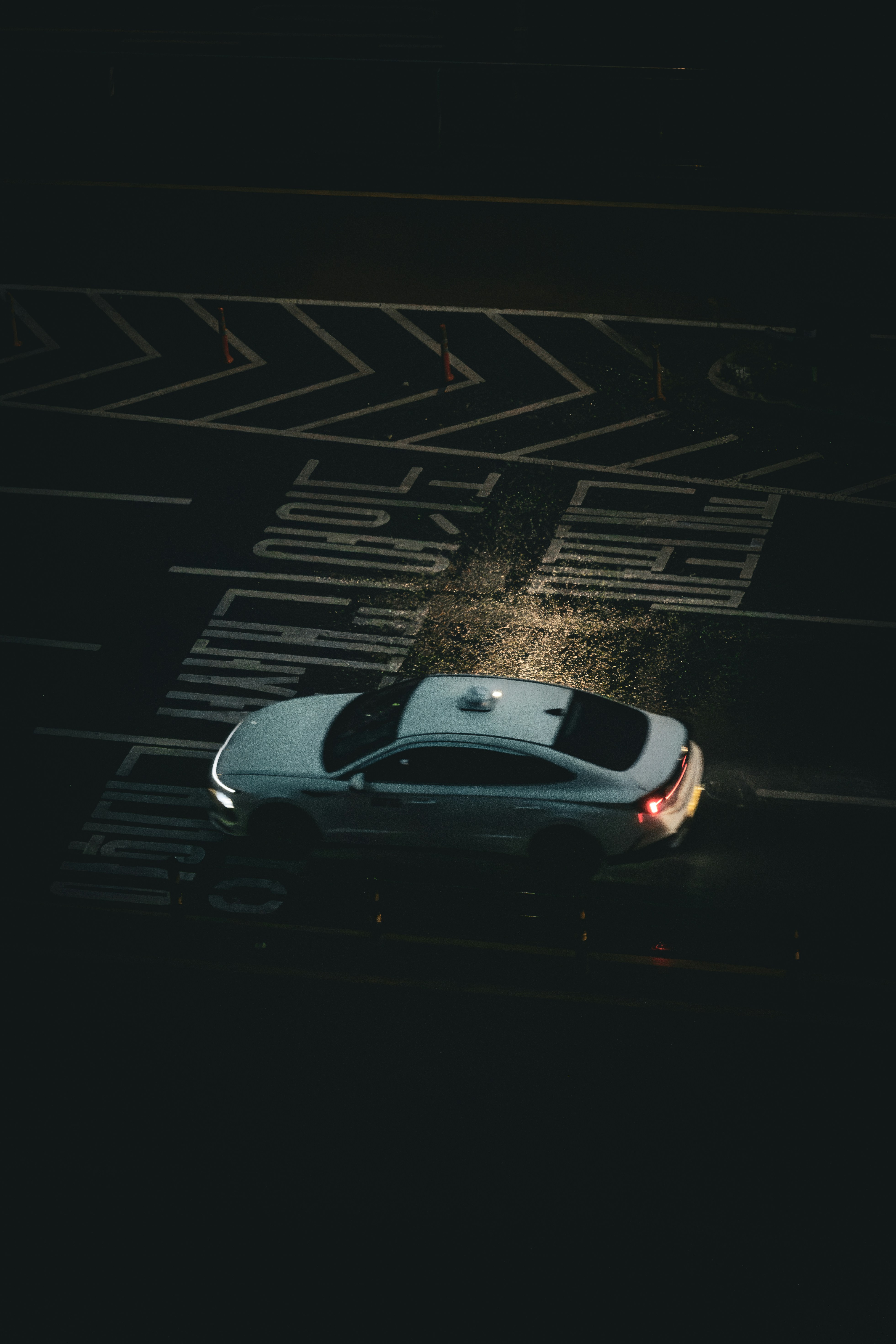 Night Run on Reflective Stripes: A Silver Sedan in Rain