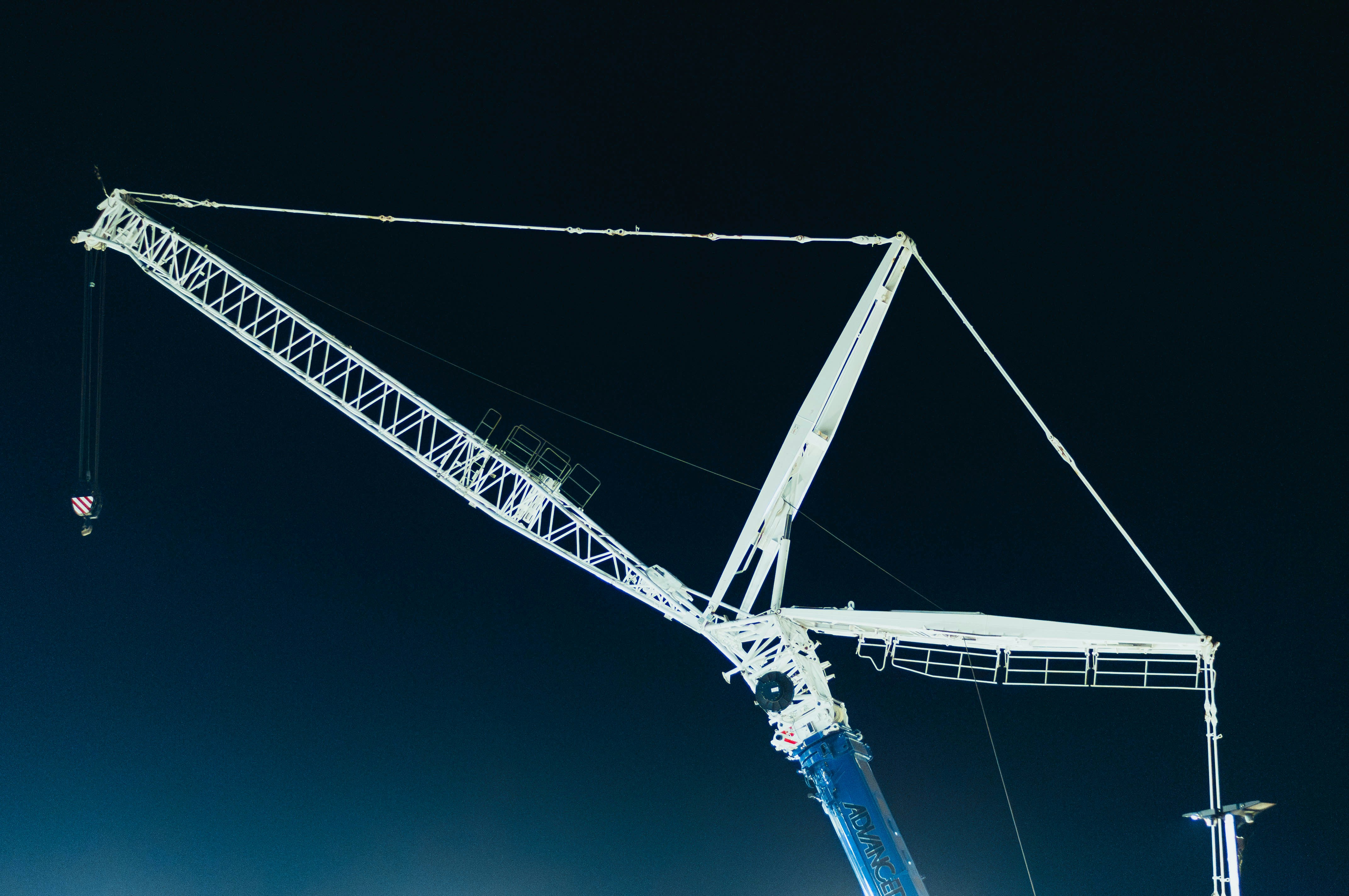 Towering crane silhouetted against a dark sky, showcasing its intricate structure and engineering prowess.