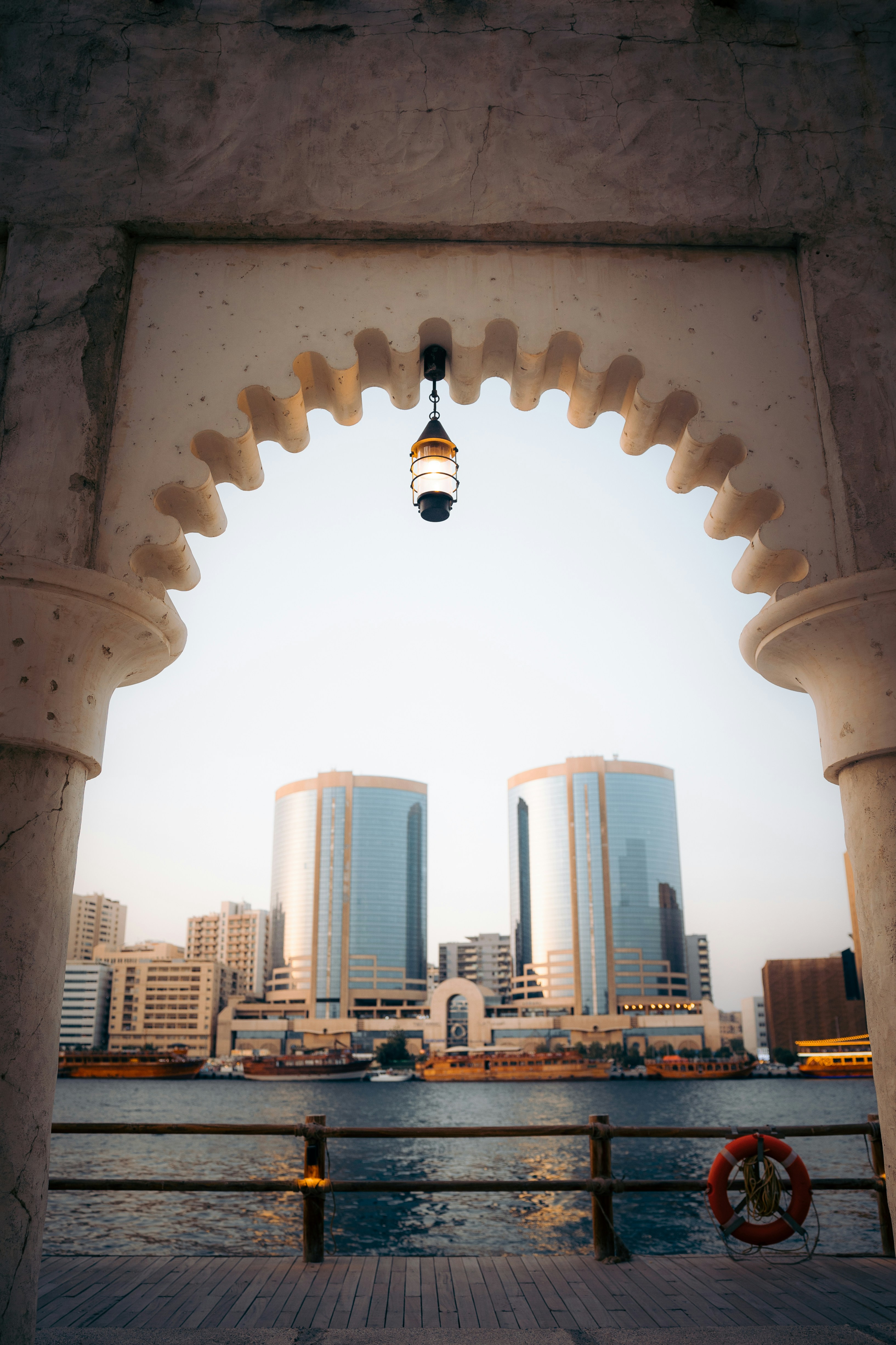 Ornate archway frames modern buildings across water photo – Free Image ...
